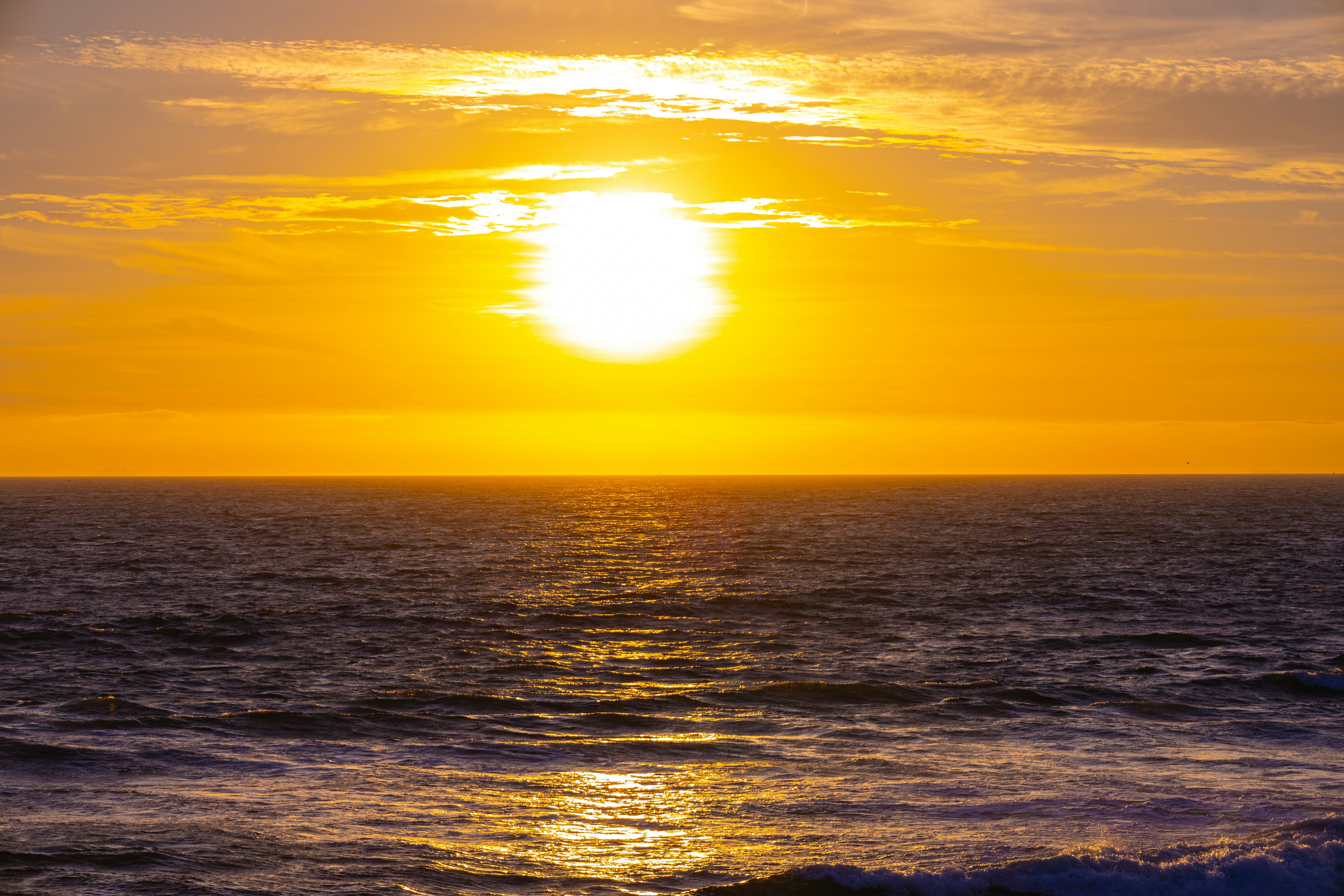 The sun is setting over the ocean on a cloudy day photo – Free Sunset ...