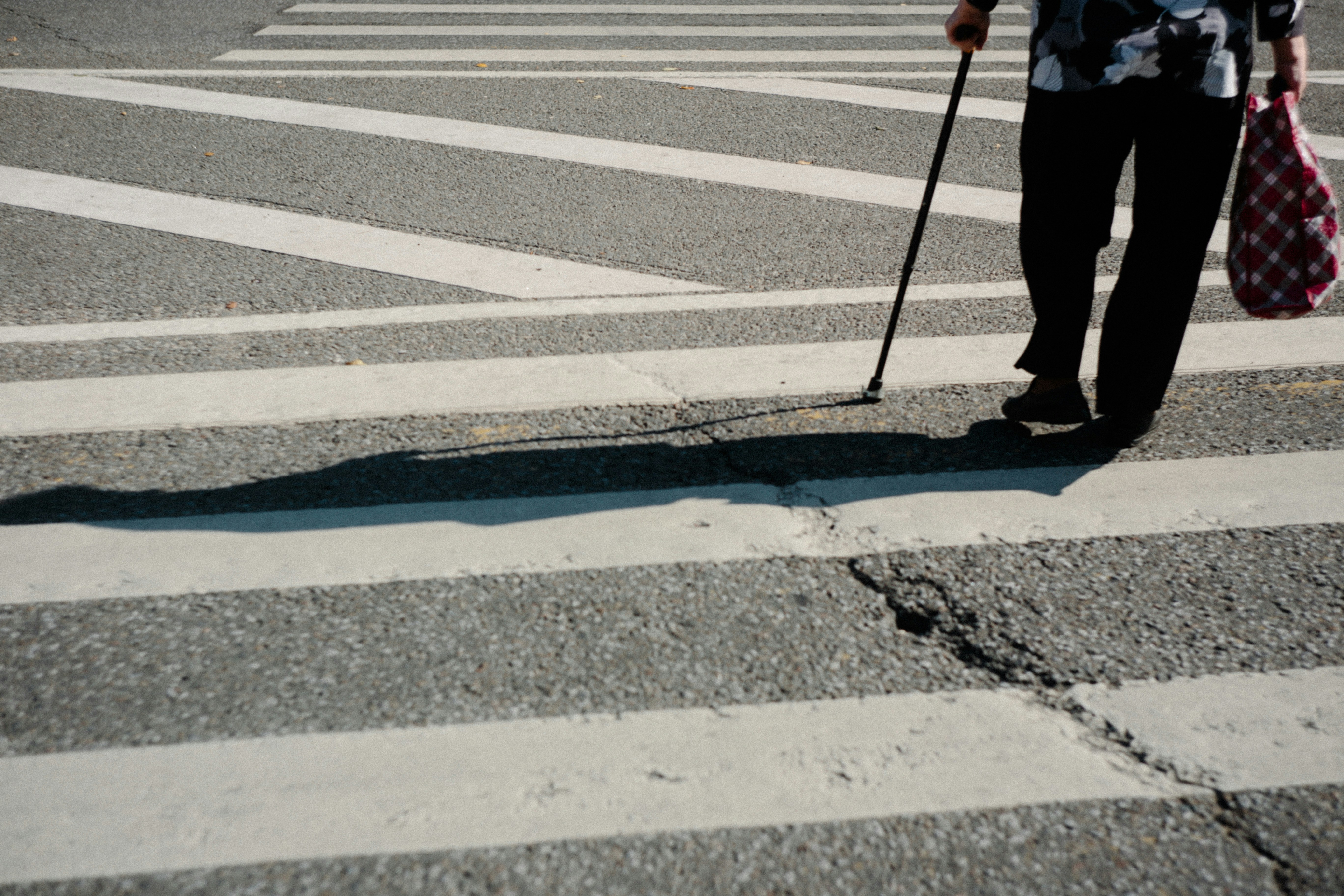 A man walking across a cross walk with a cane photo – Free Old woman ...