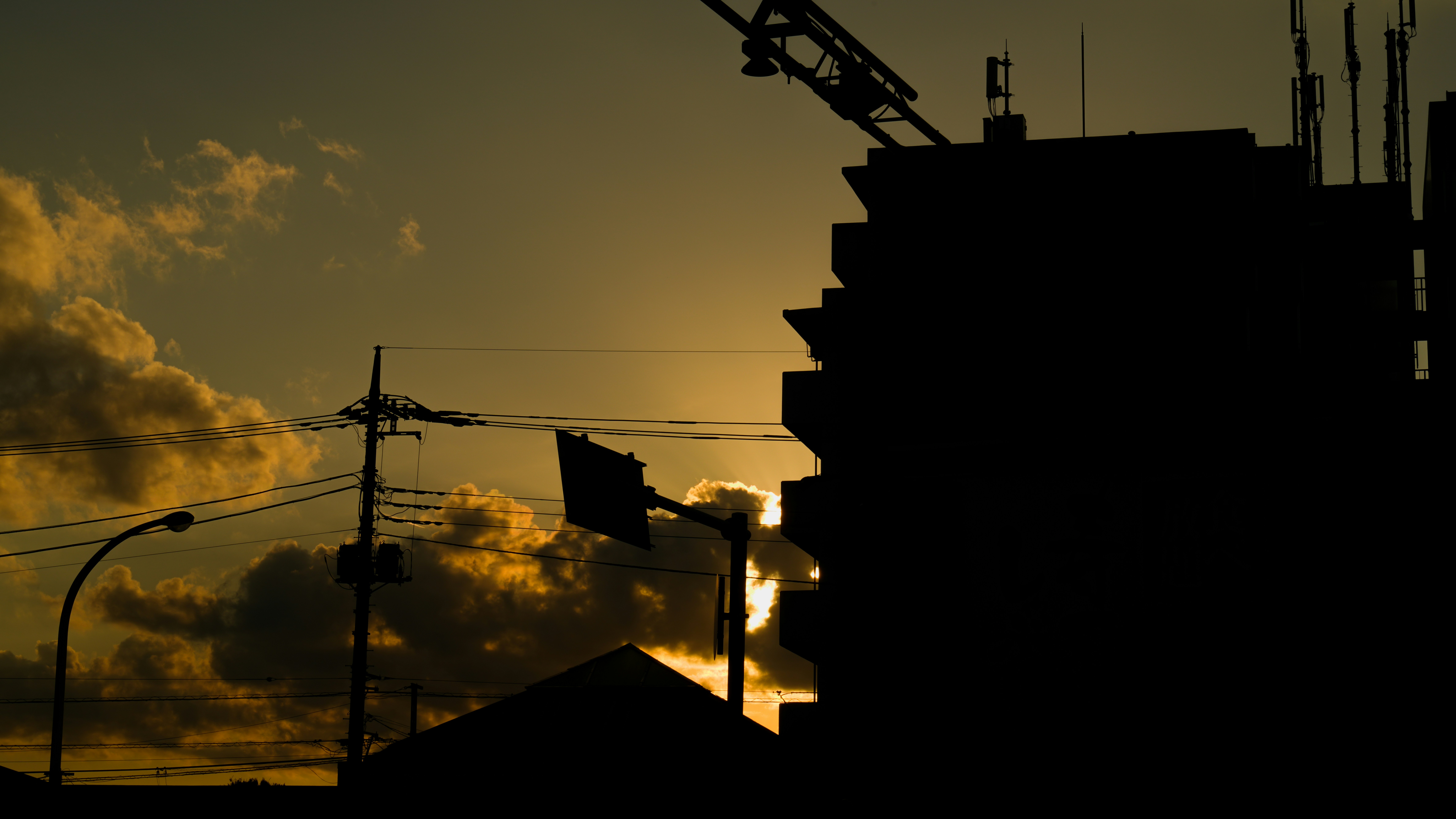 Crane-Outlined Dusk: A City Silhouette Against a Golden Sky