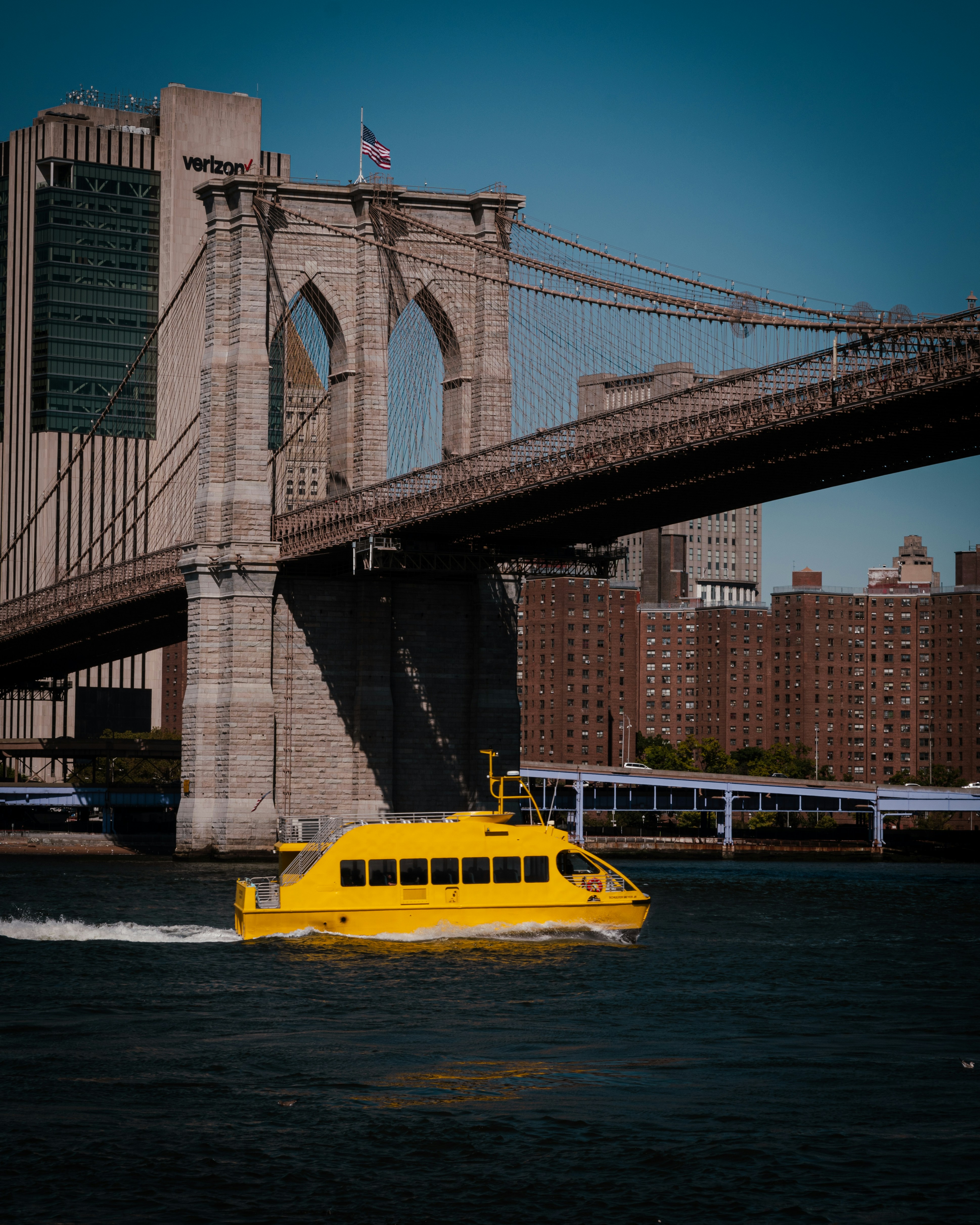 Un barco amarillo pasa por debajo de un puente foto – Imagen de Nueva ...