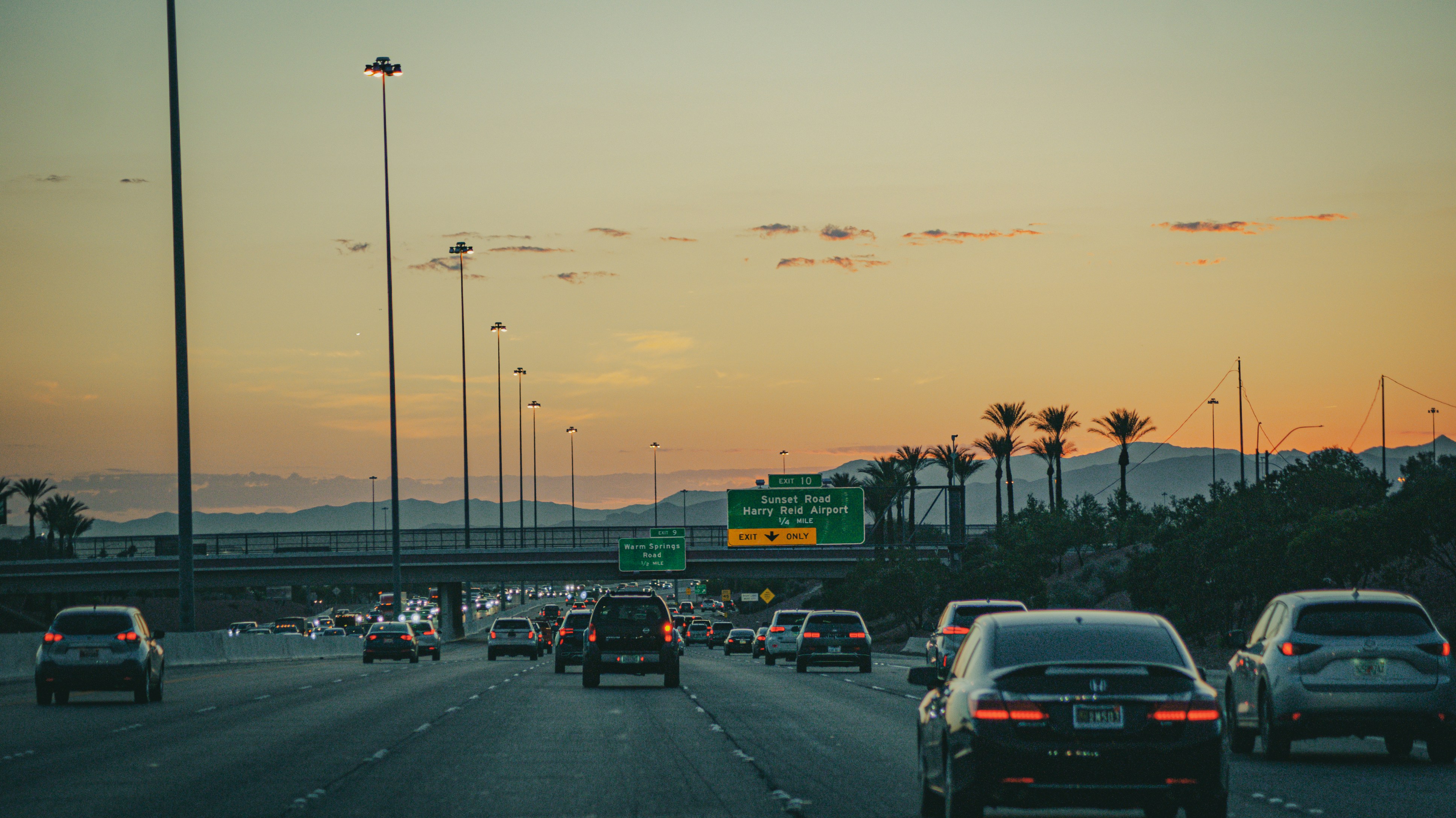 A group of cars driving down a highway at sunset photo – Free Las vegas ...