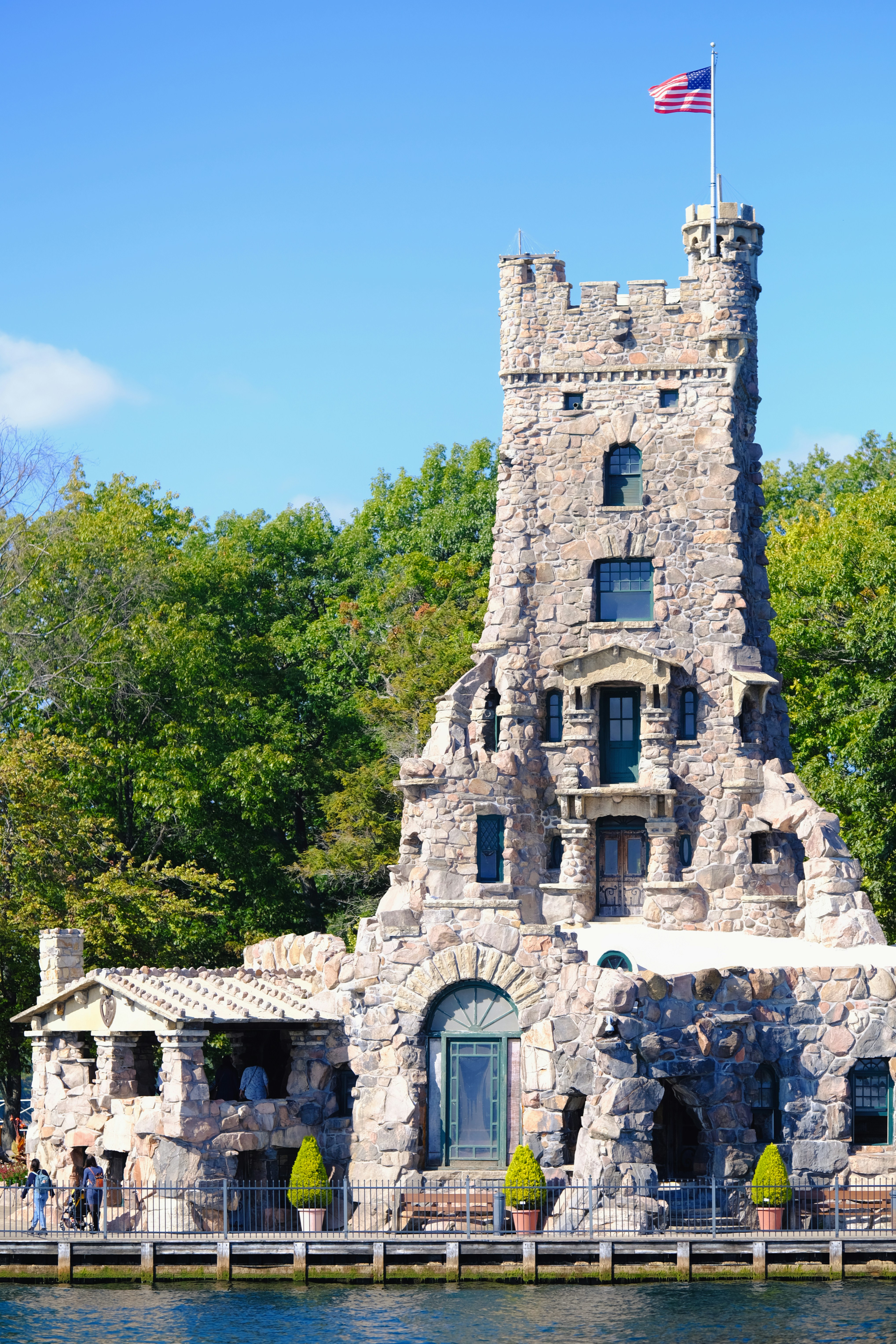 Flag-Topped Granite Tower Rising Over a Lakeside Fortress