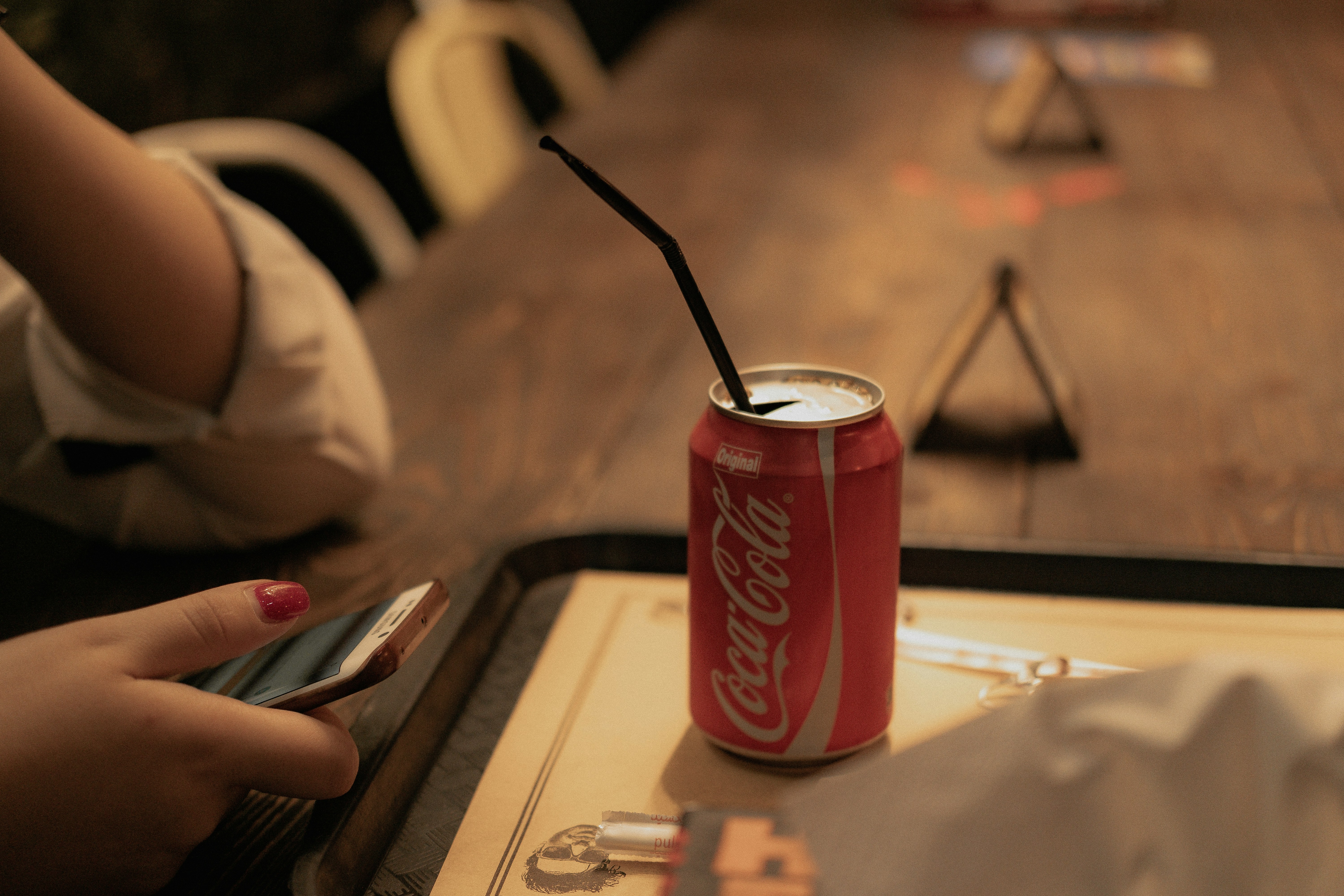 Red Can in Soft Café Glow: A Quiet Moment at the Table