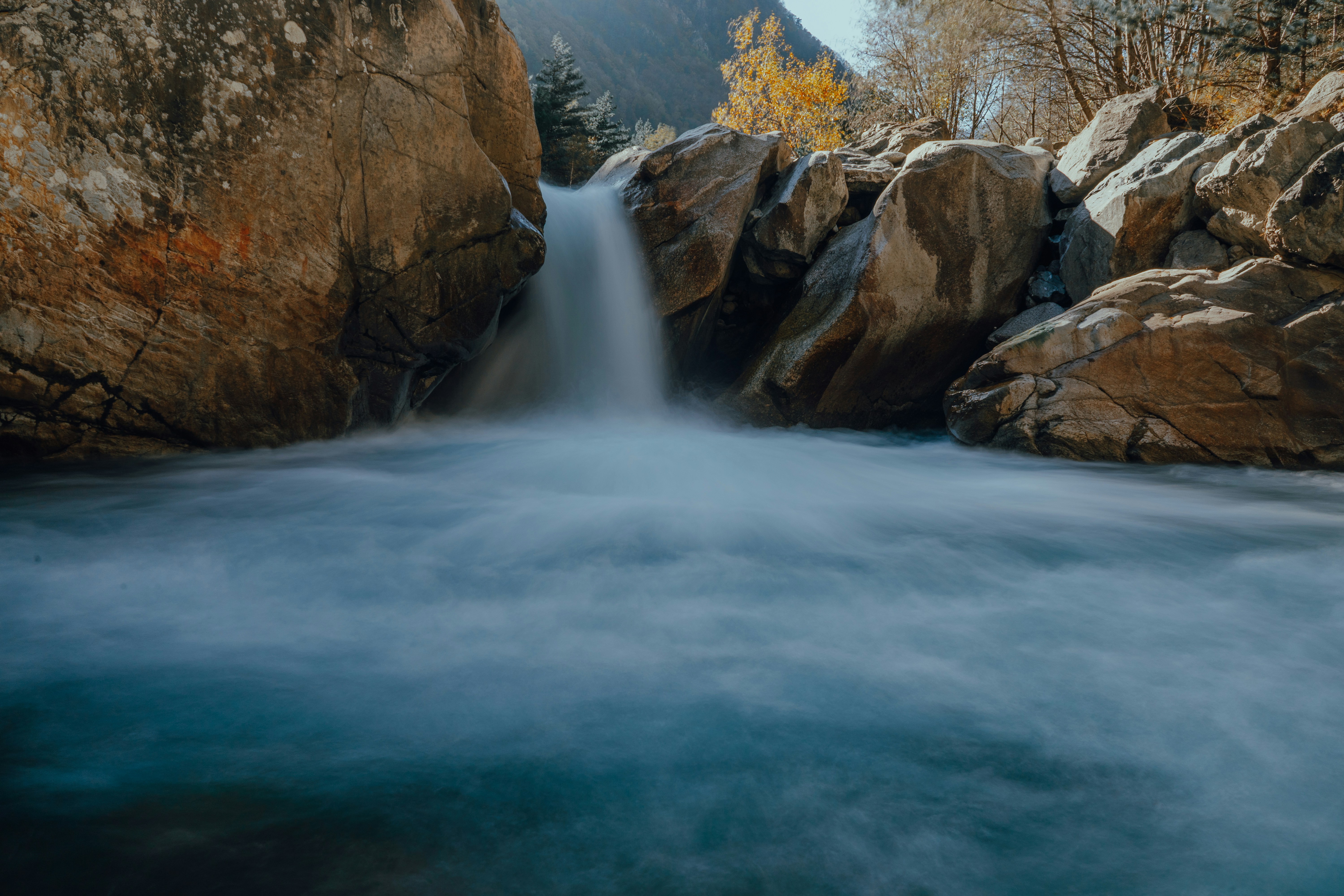A stream of water running between two large rocks photo – Free North ...