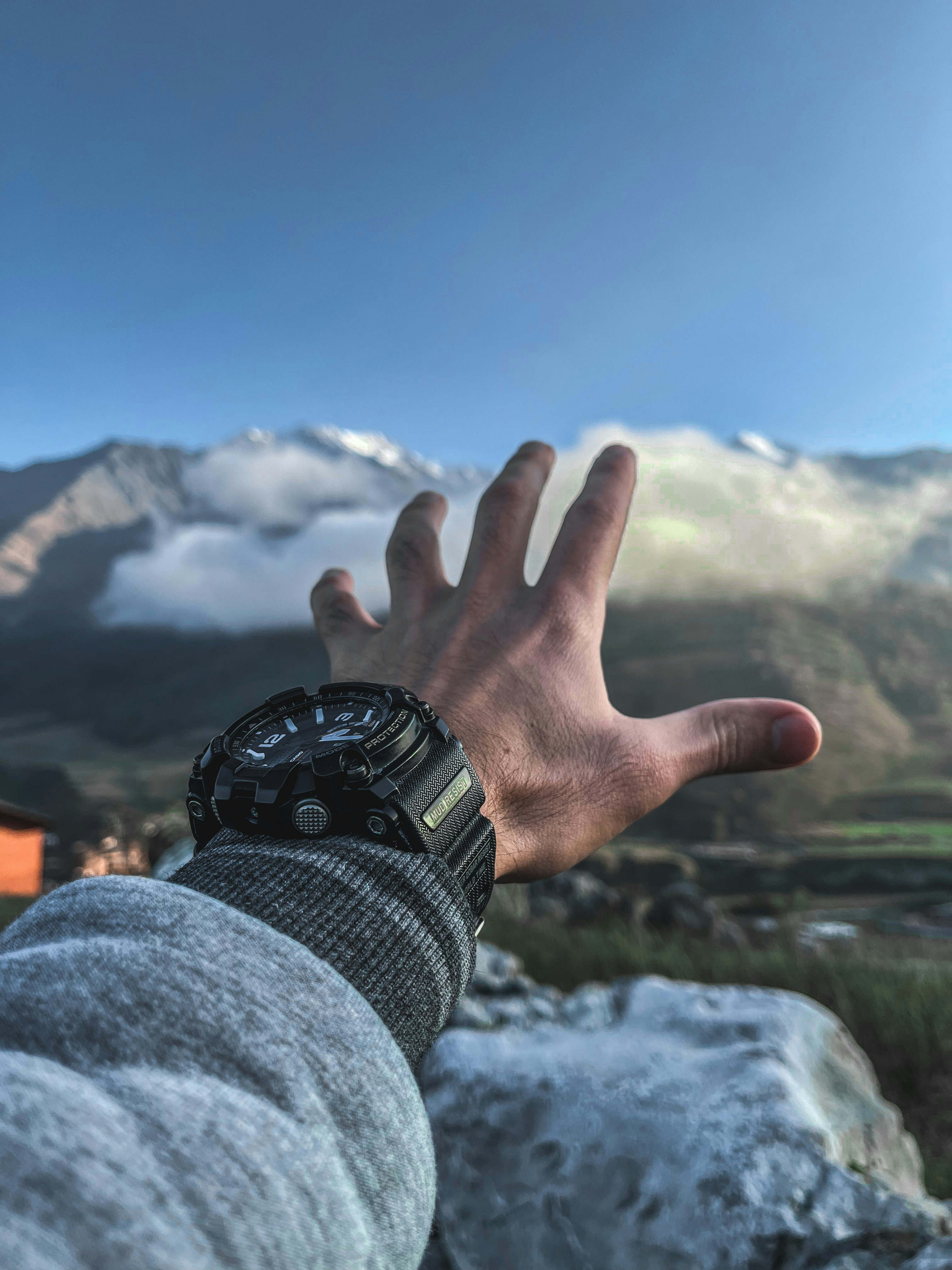 Alpine Reach: A Rugged Watch Framed Against Sky and Ridge