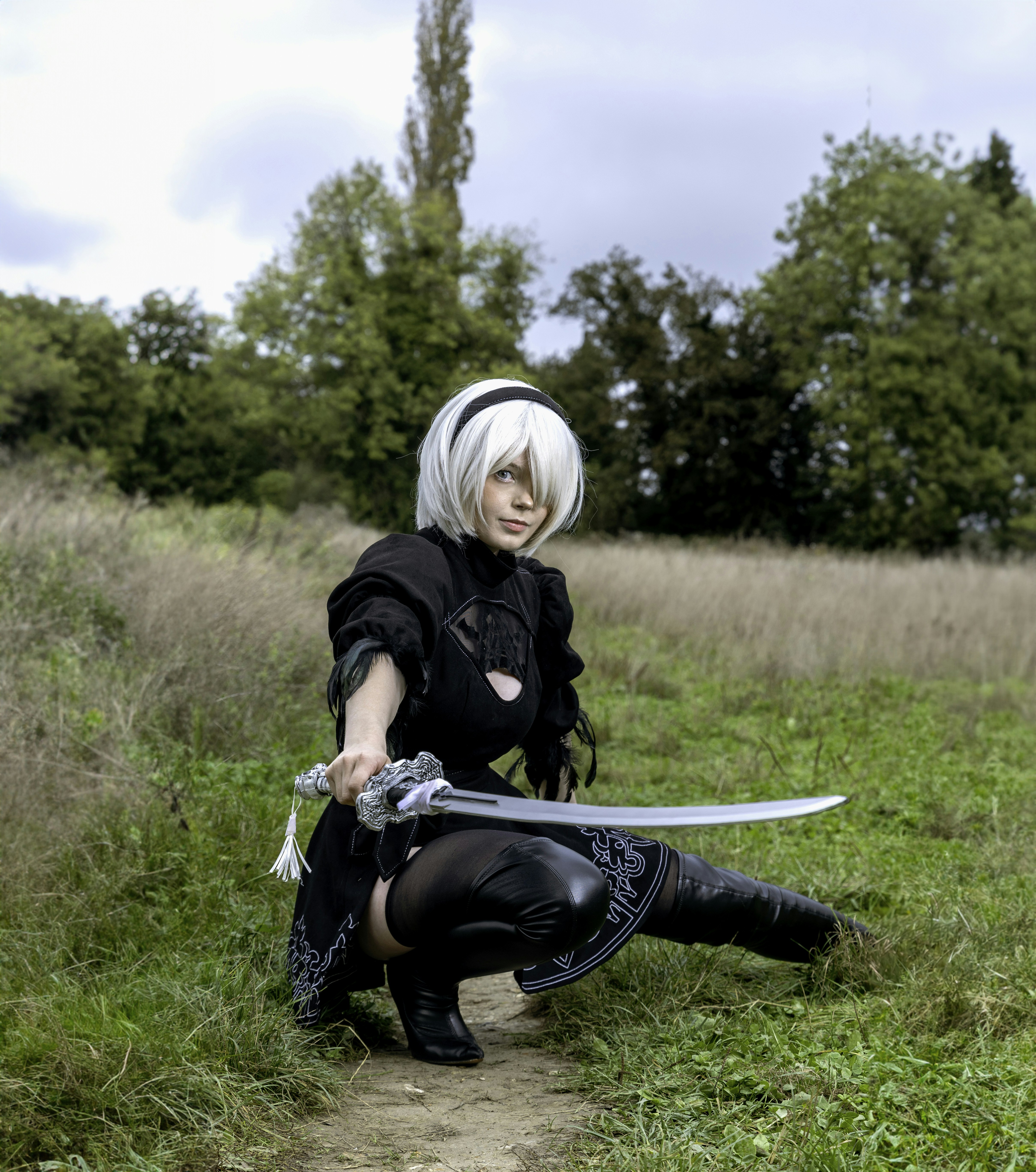 A woman in a black outfit holding a sword photo – Free Sword Image on ...