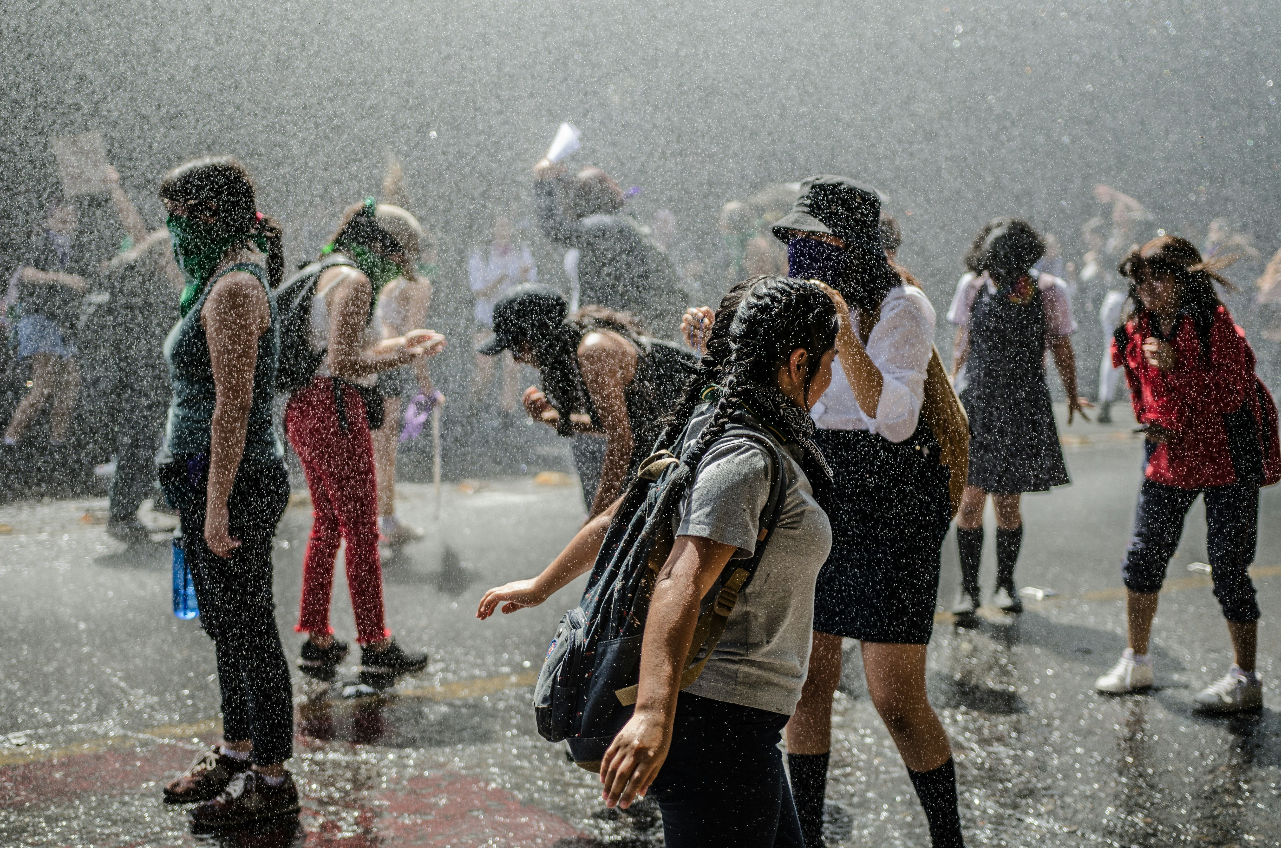 A group of people standing around in the rain photo – Free Woman Image ...