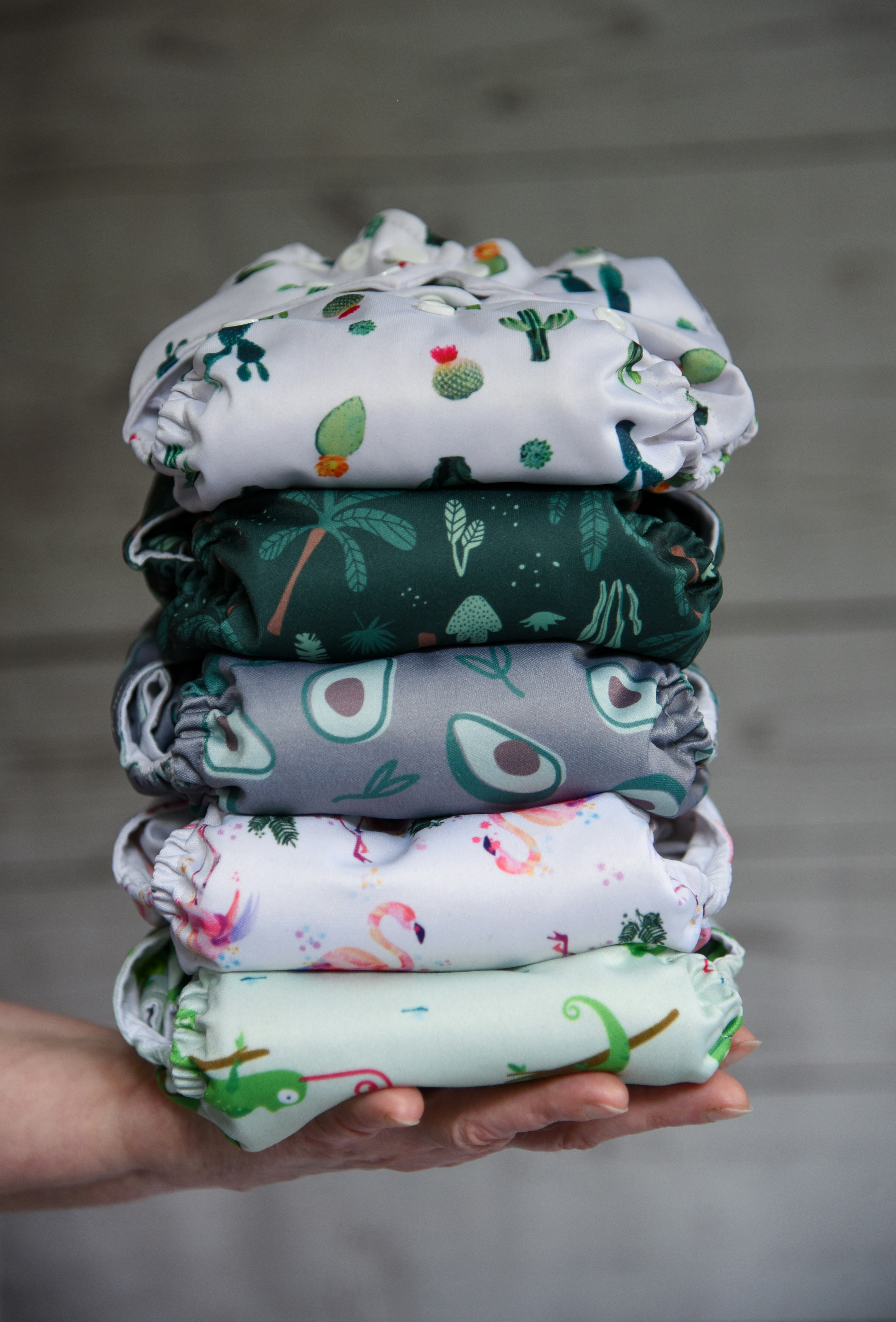 A person holding a stack of cloths in their hands photo – Free Cloth ...