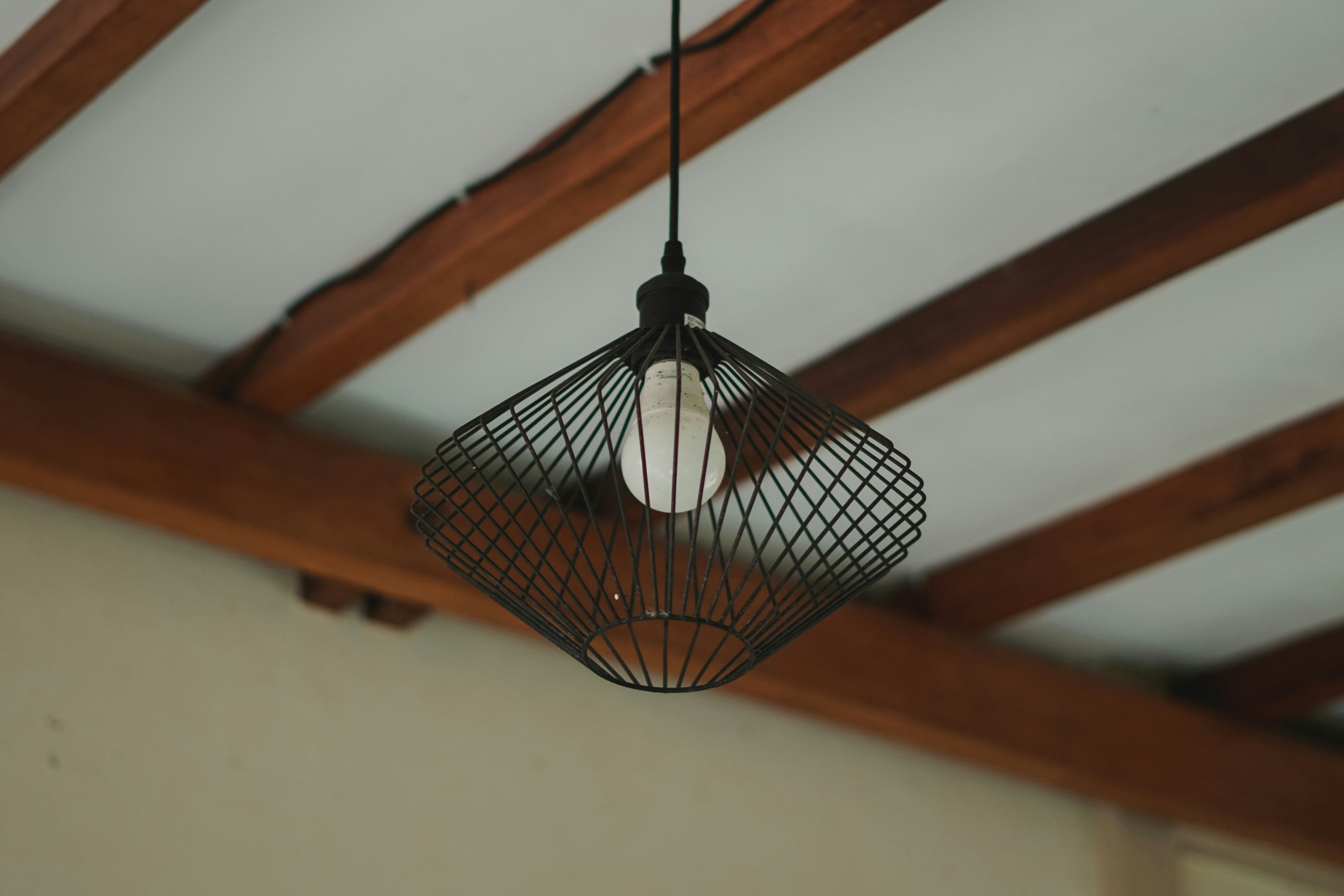 A caged light fixture hanging from a ceiling photo – Free Ceiling Image ...