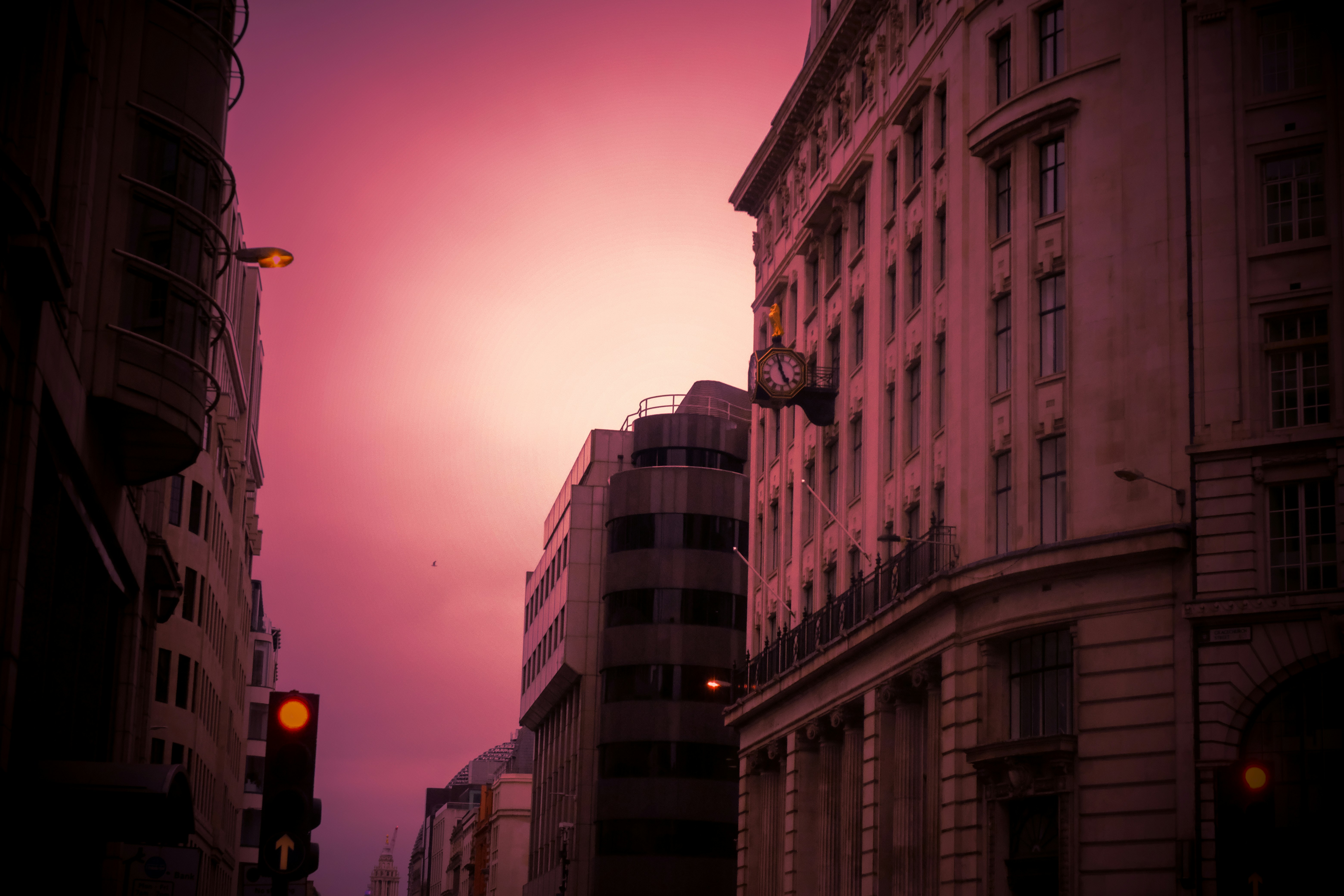 A red traffic light hanging from the side of a tall building photo ...