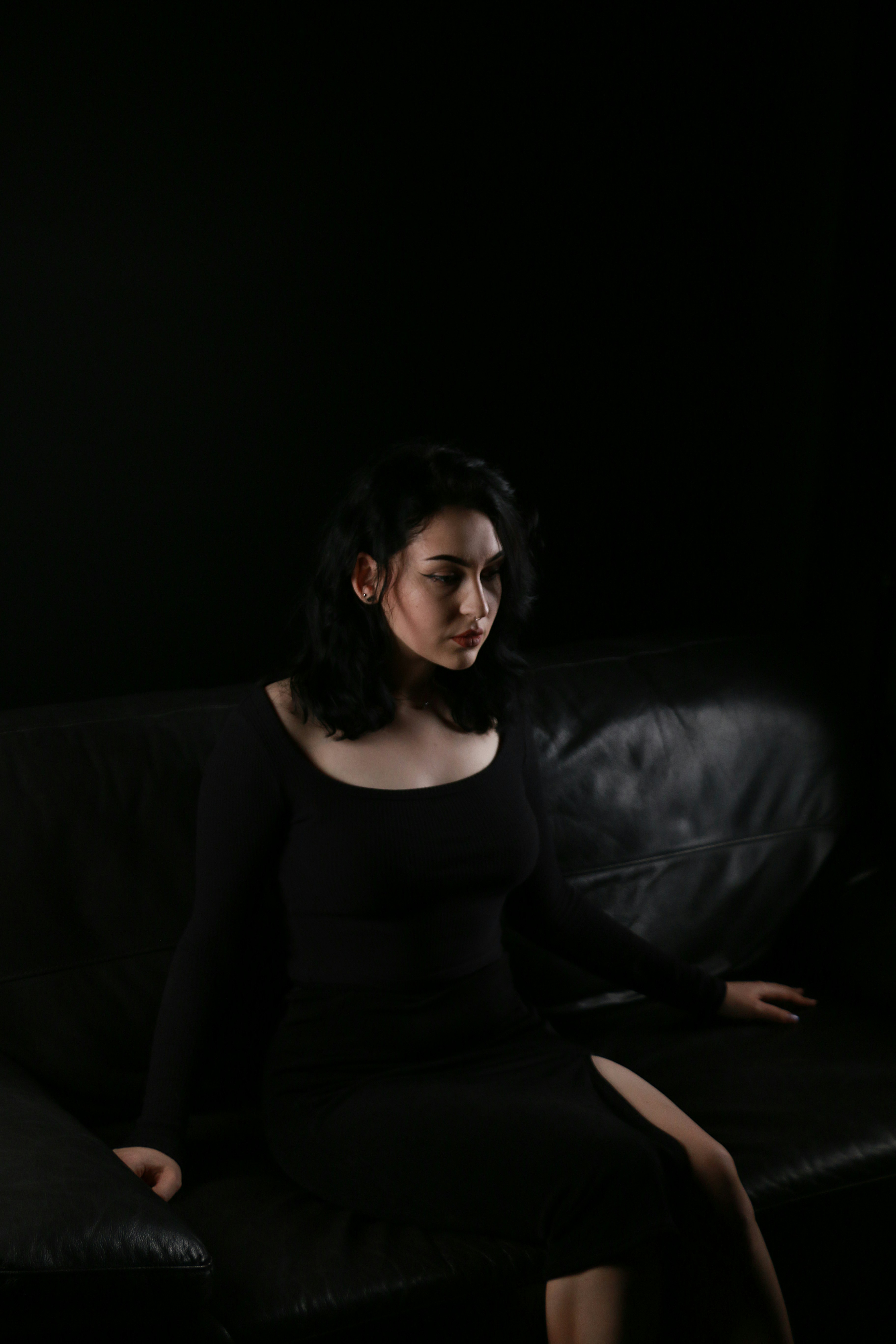 Velvet Shadows: A Contemplative Portrait on a Leather Sofa