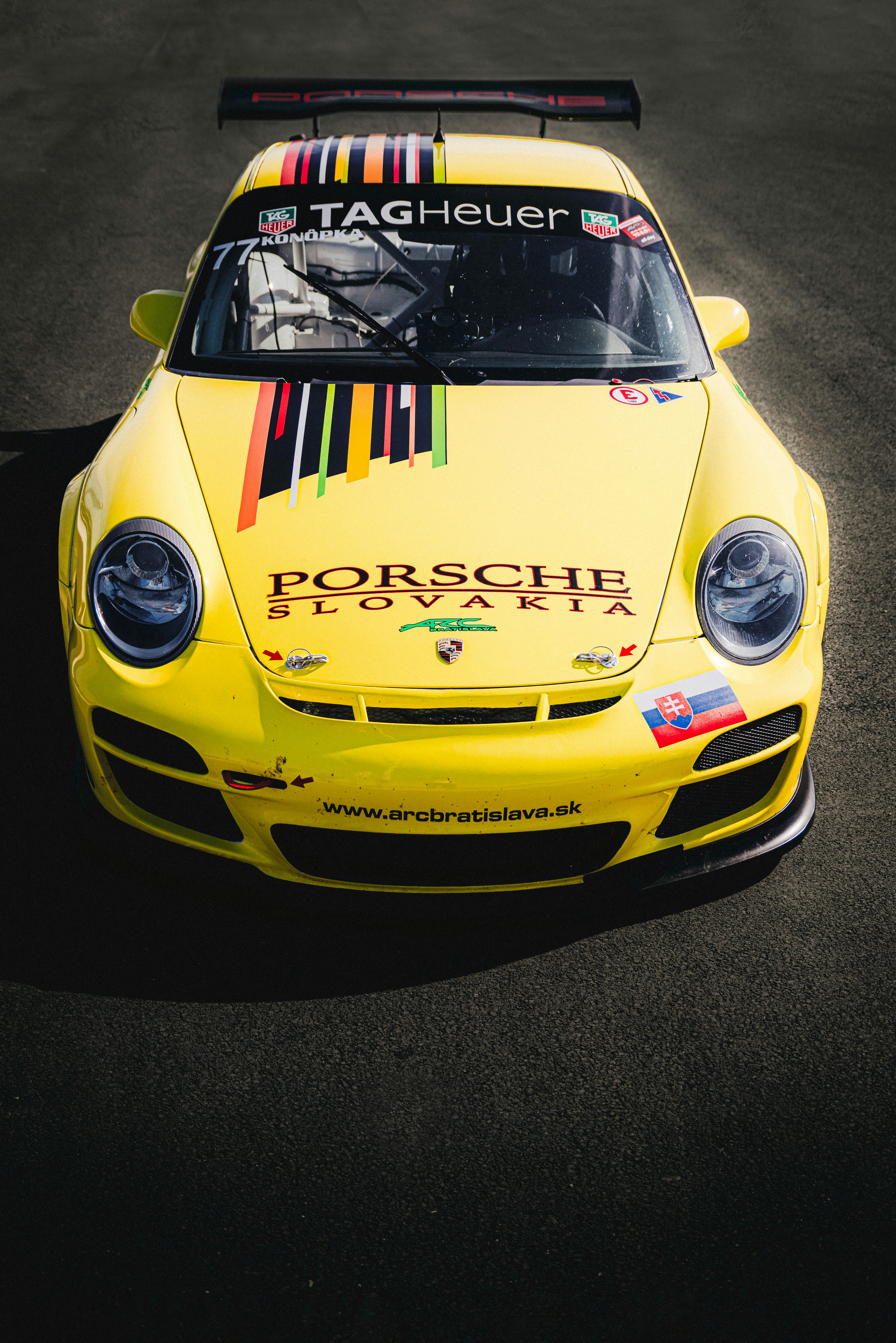 Neon Porsche on Tarmac: Striped Livery Under Sun