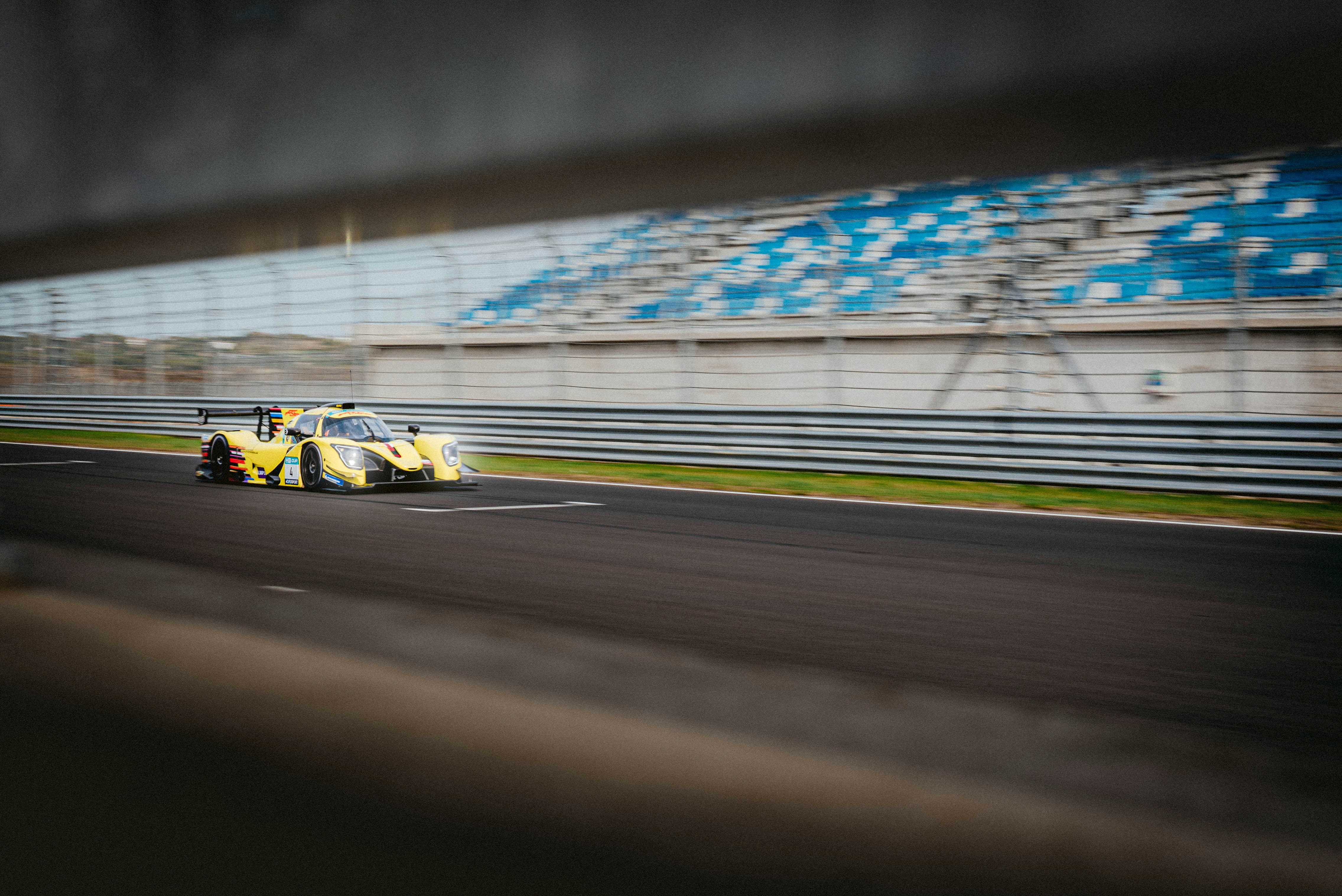 A yellow race car driving down a race track photo – Free Balaton park ...
