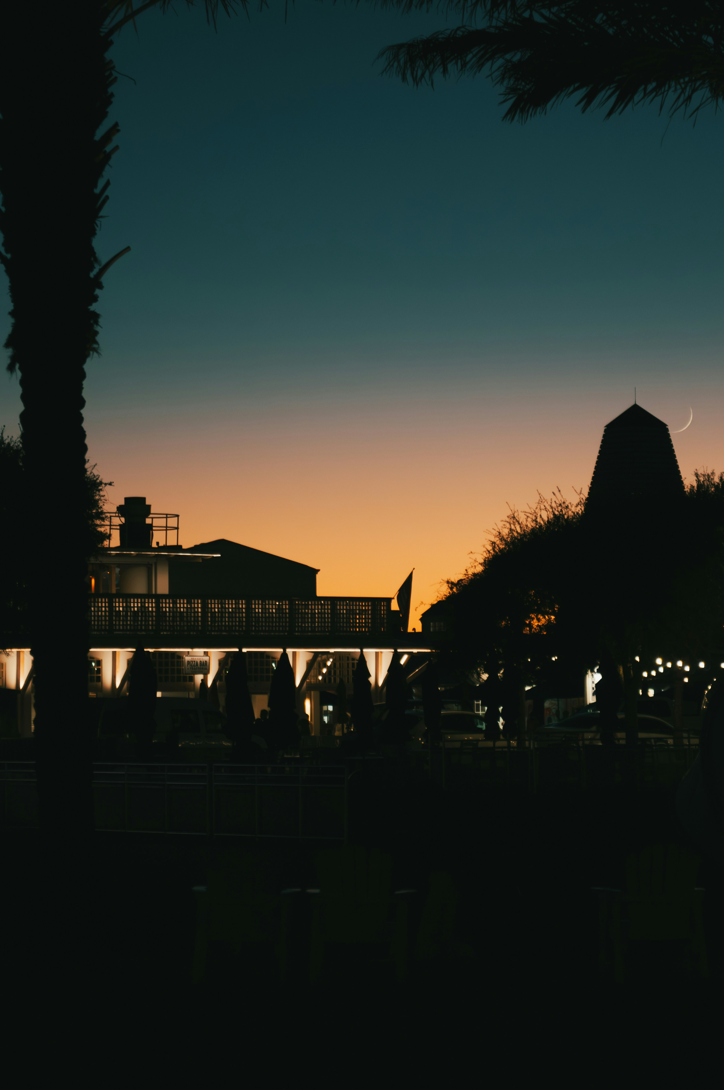 Crescent Over Twilight Pier: Silhouettes Against a Gradient Sky