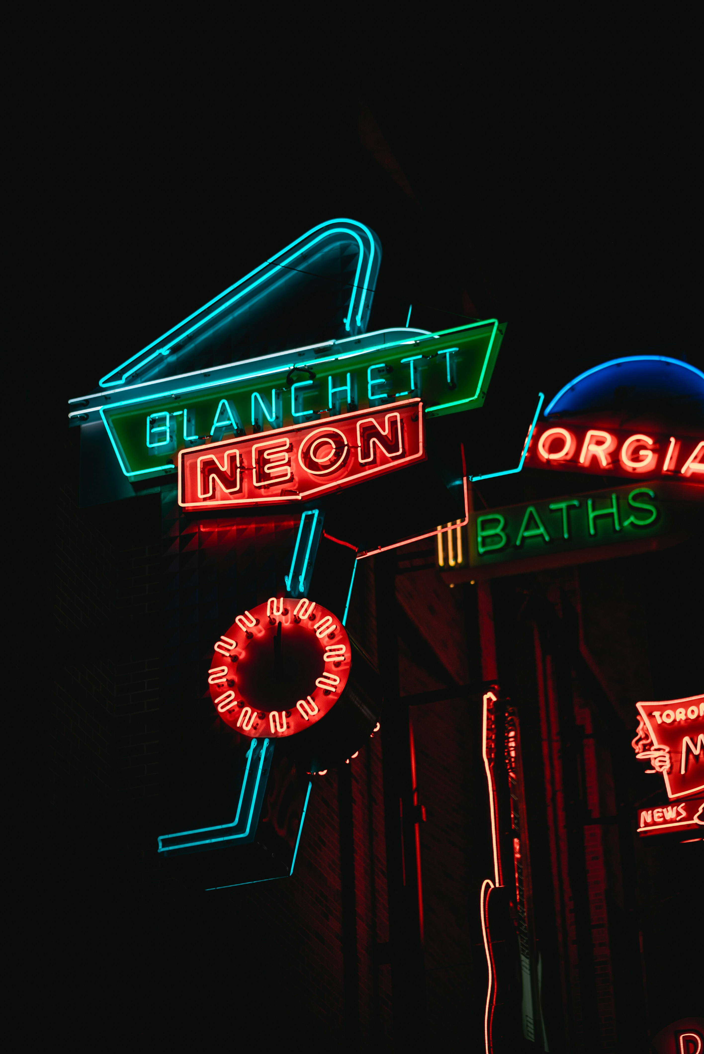 A bunch of neon signs that are on the side of a building photo – Free ...