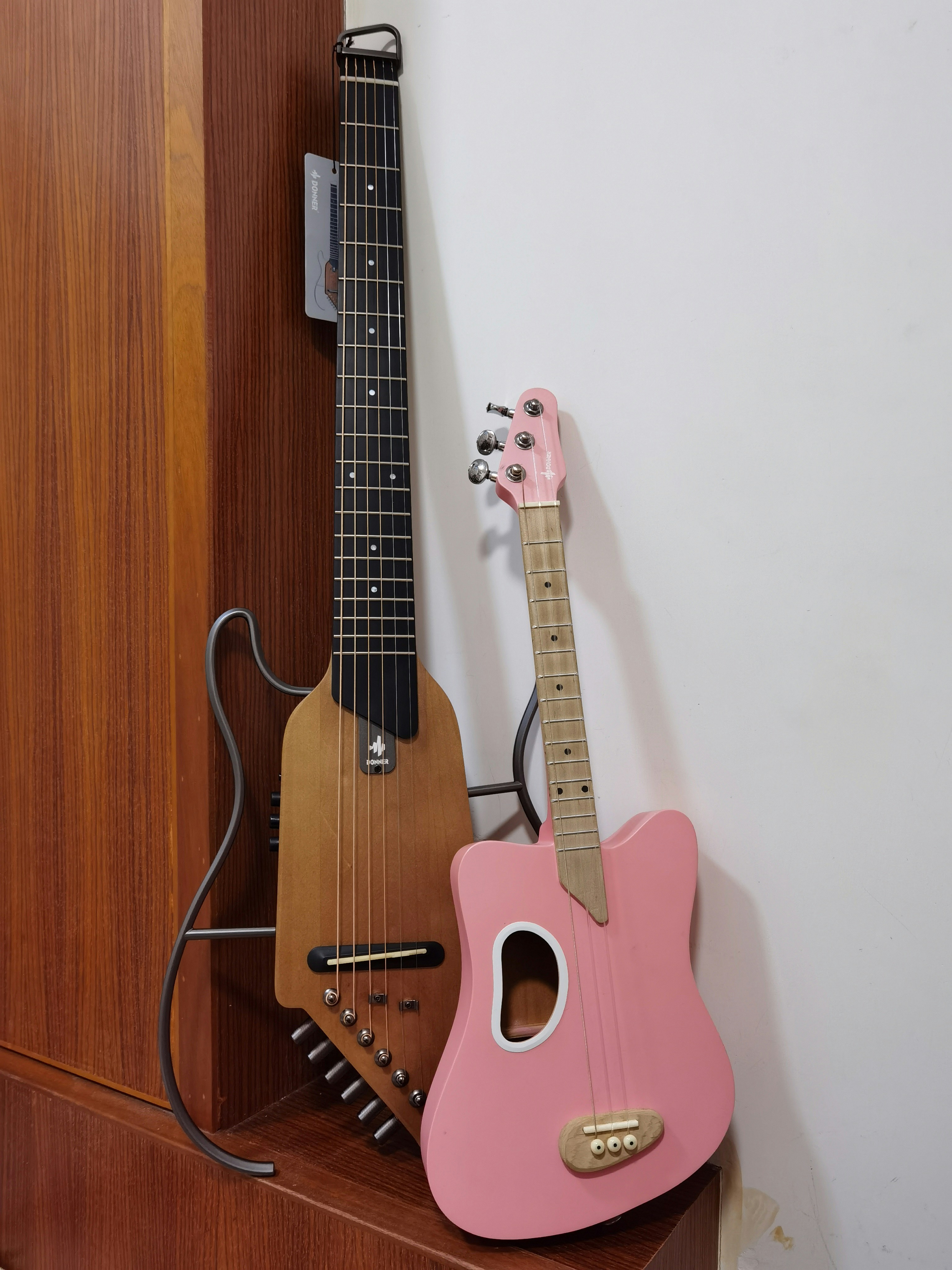 A pink ukulele and a pink ukulele sit on a shelf photo – Free Guitar ...