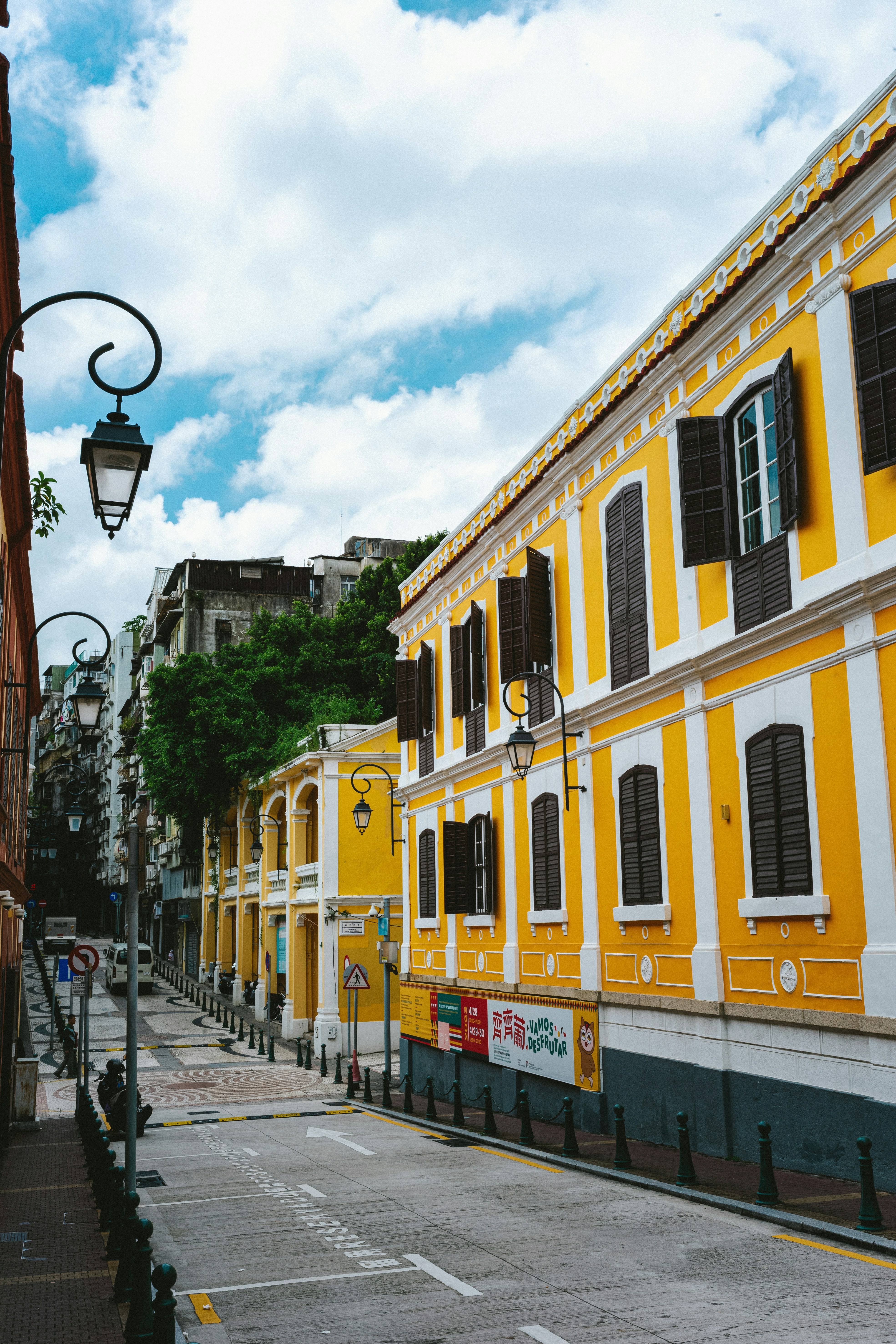 A row of yellow buildings on a city street photo – Free Street Image on ...
