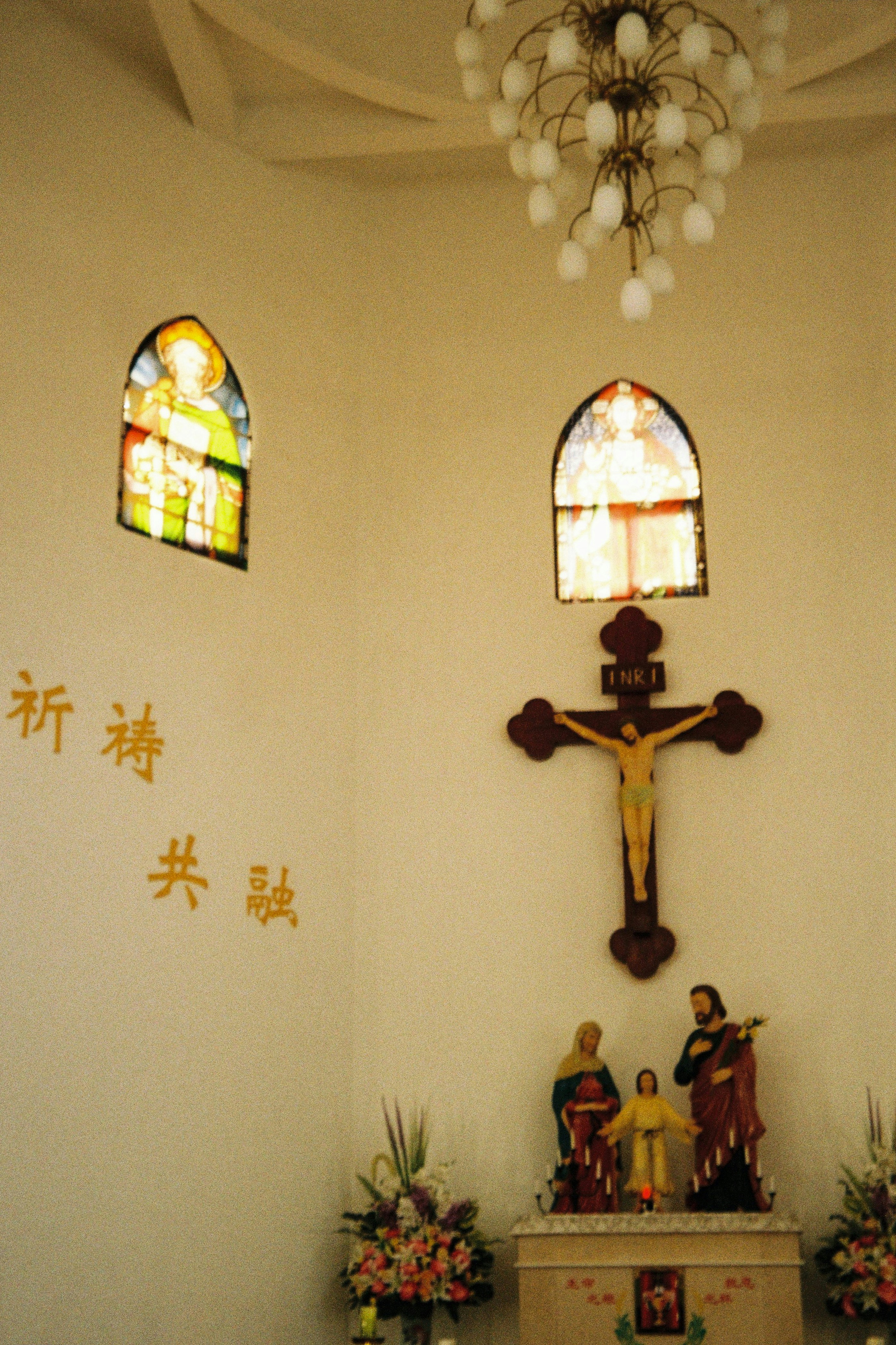 Crucifix in Focus: A Quiet Chapel Moment Beneath Stained Glass
