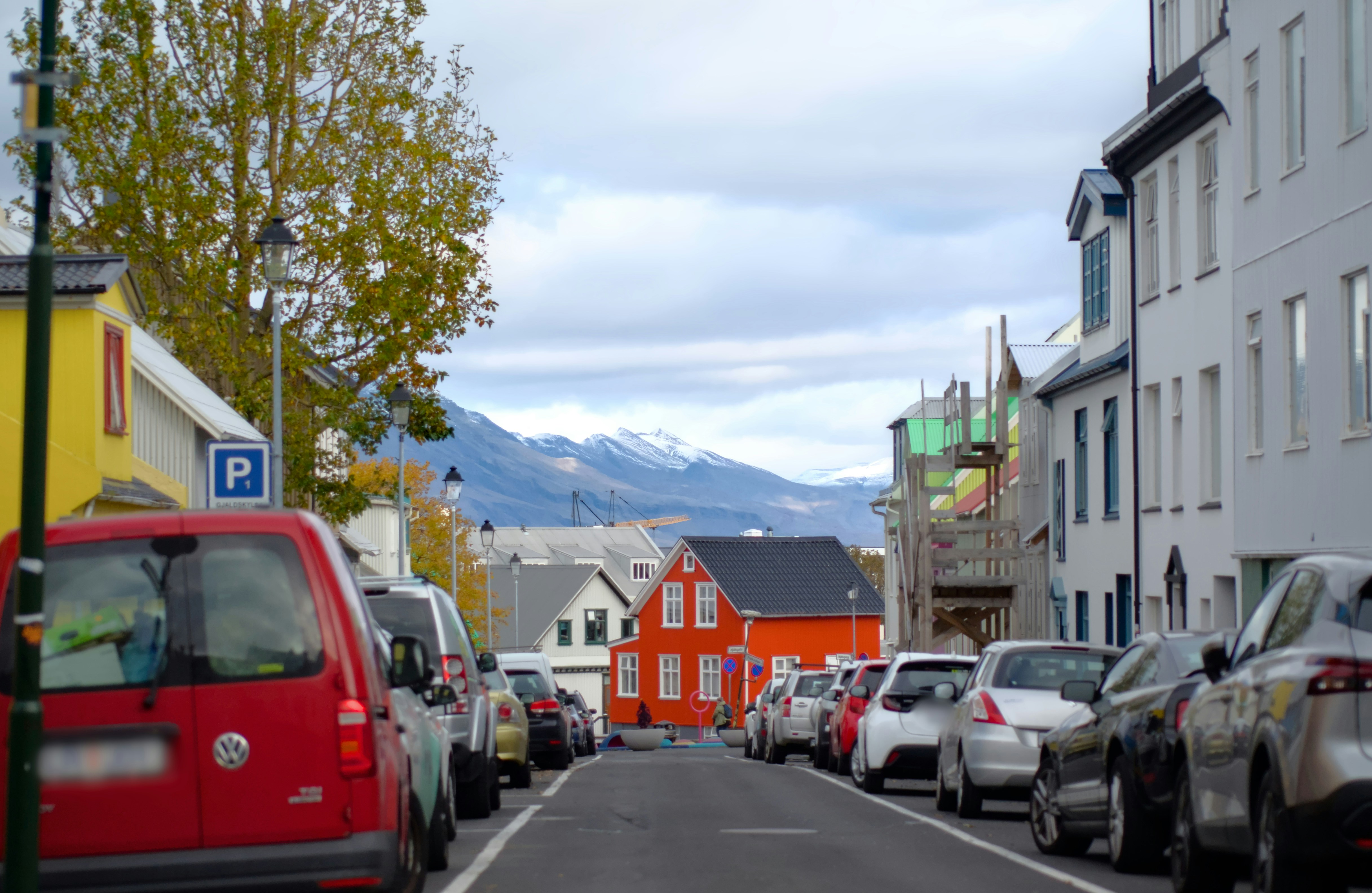 a street lined with parked cars next to tall buildings
