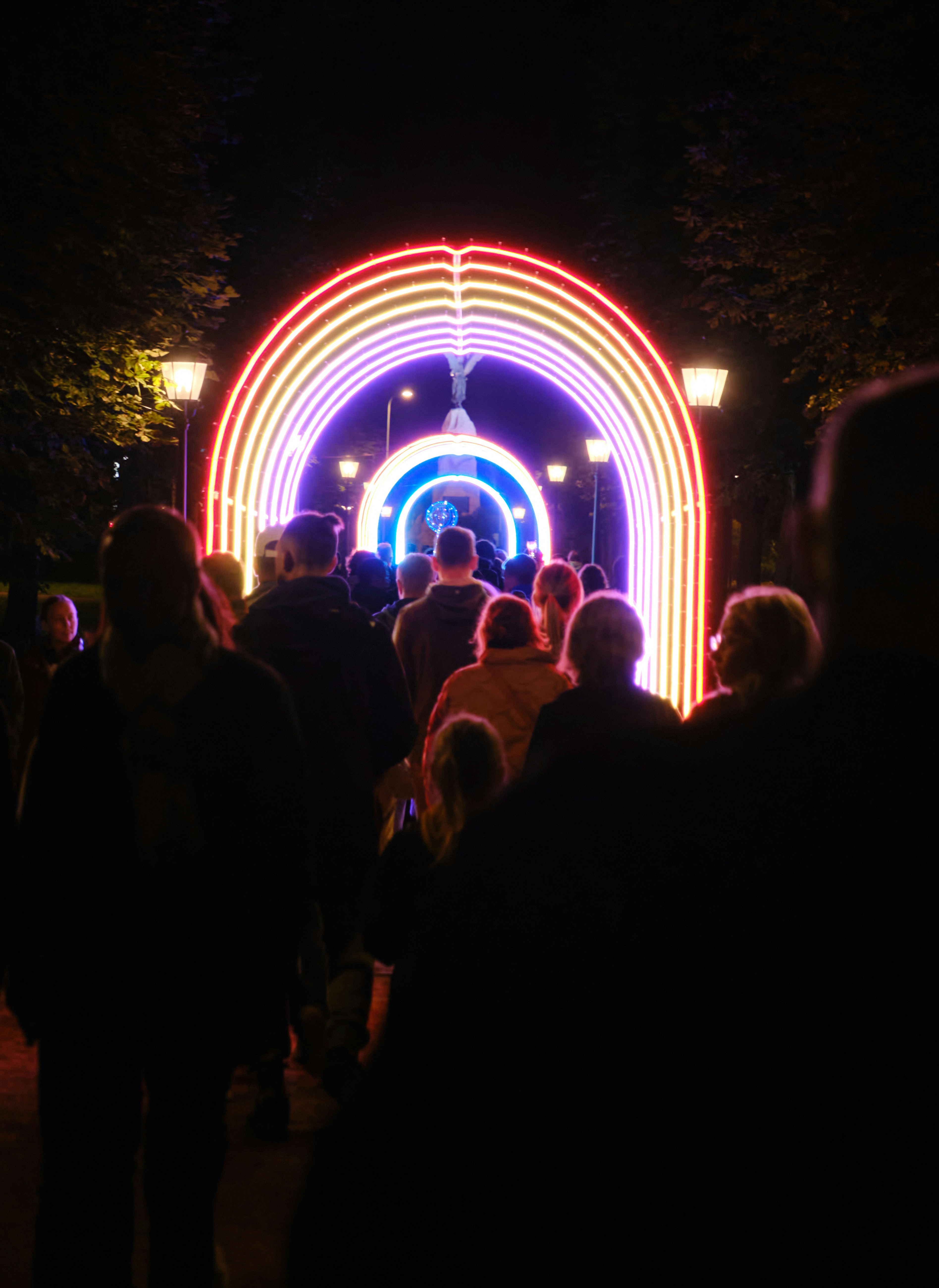 Neon Arcade: Crowd Walks Through a Ring of Light