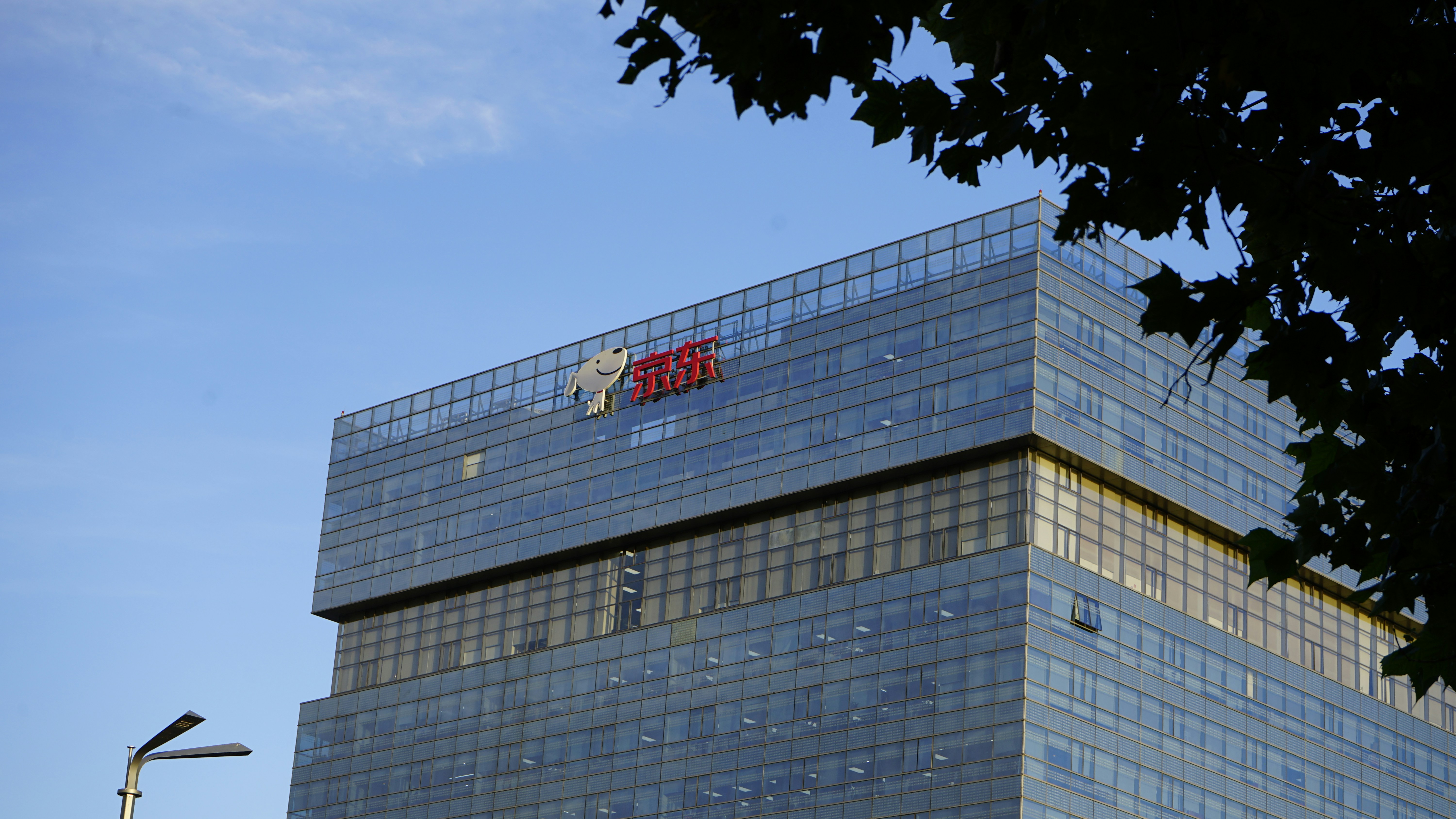 Modern glass skyscraper with company logo under blue sky. photo – Free ...