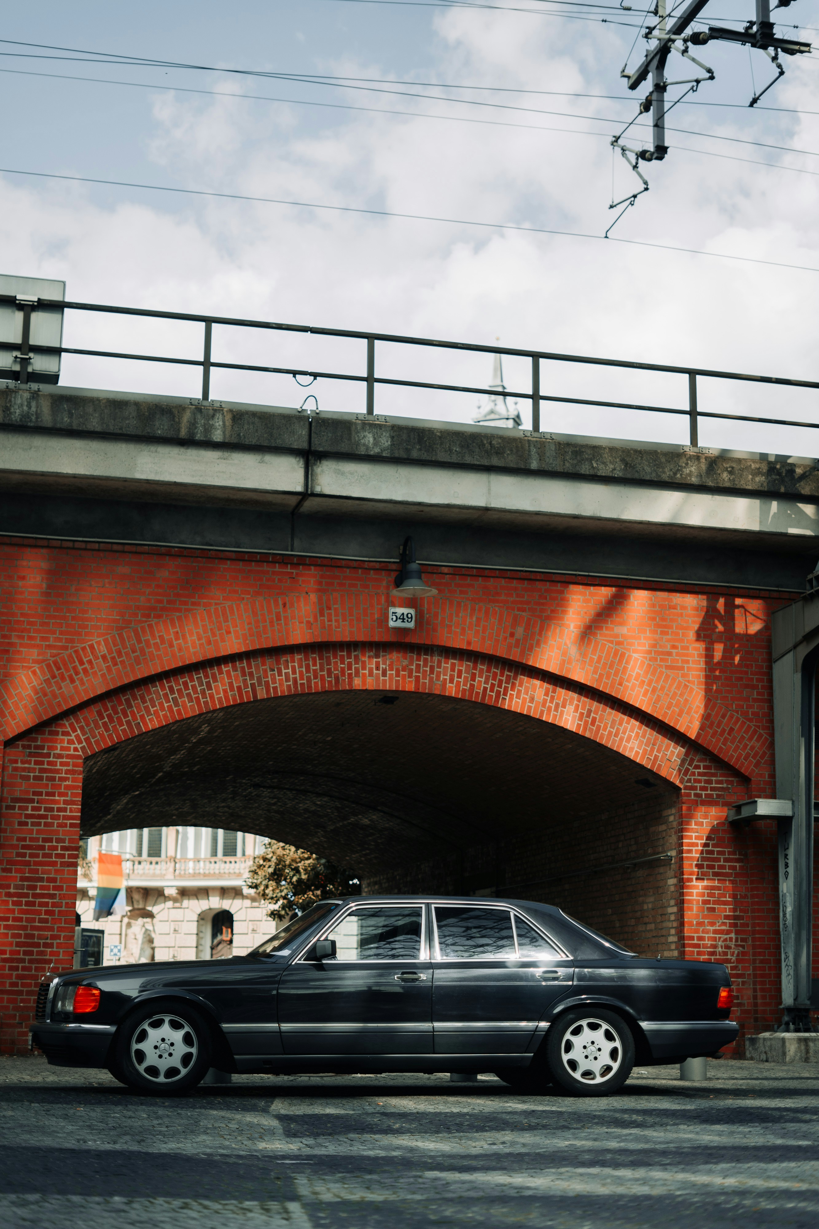 Underpass Classic: A Brushed Blue Sedan Resting in Brick Arches
