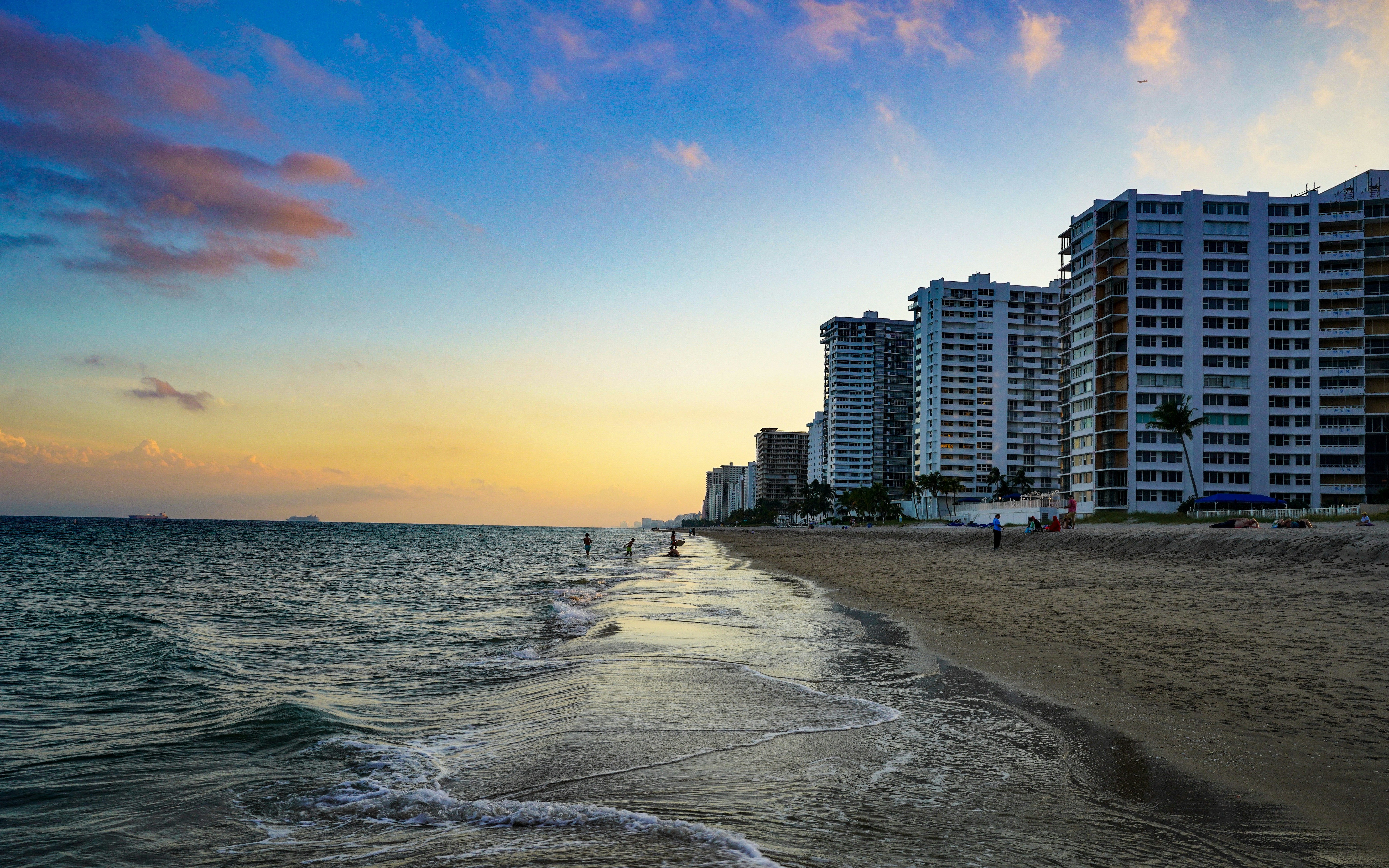 A view of a beach with buildings in the background photo – Free United ...
