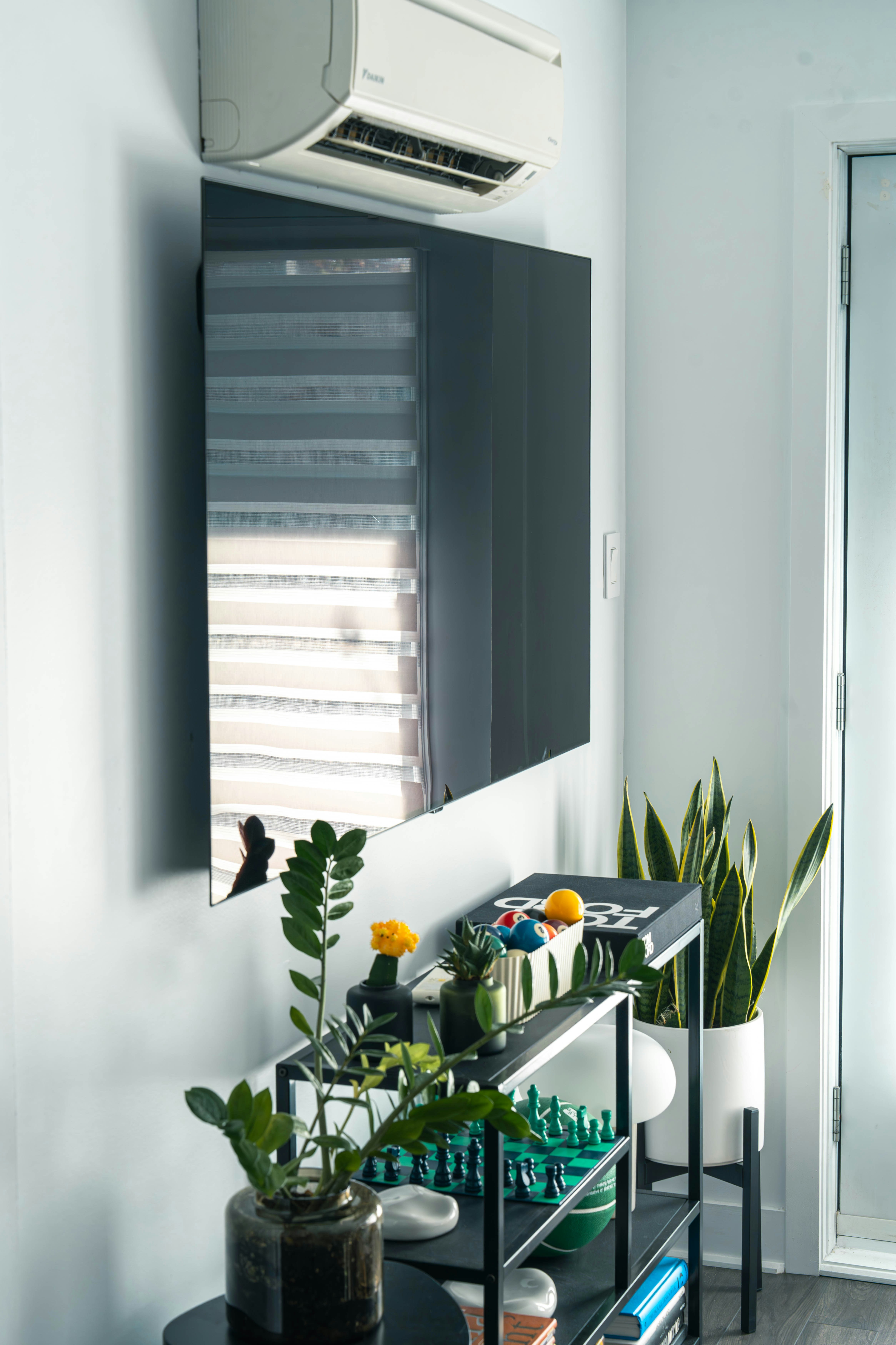 A air conditioner mounted on a wall above a shelf photo – Free Plant ...