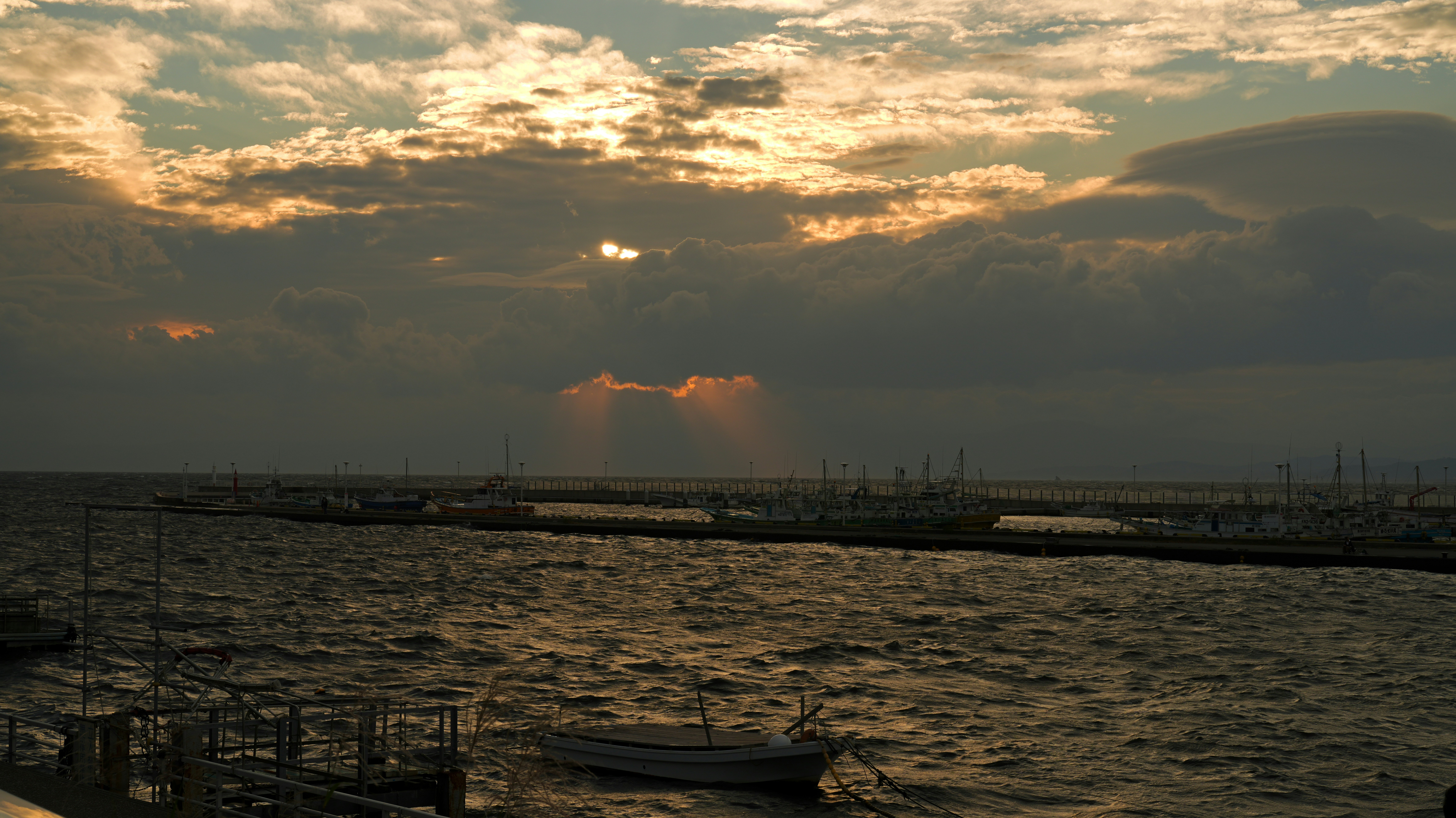 Sunbreak Over the Marina: Silhouetted Boats Beneath a Cloud-Washed Dusk