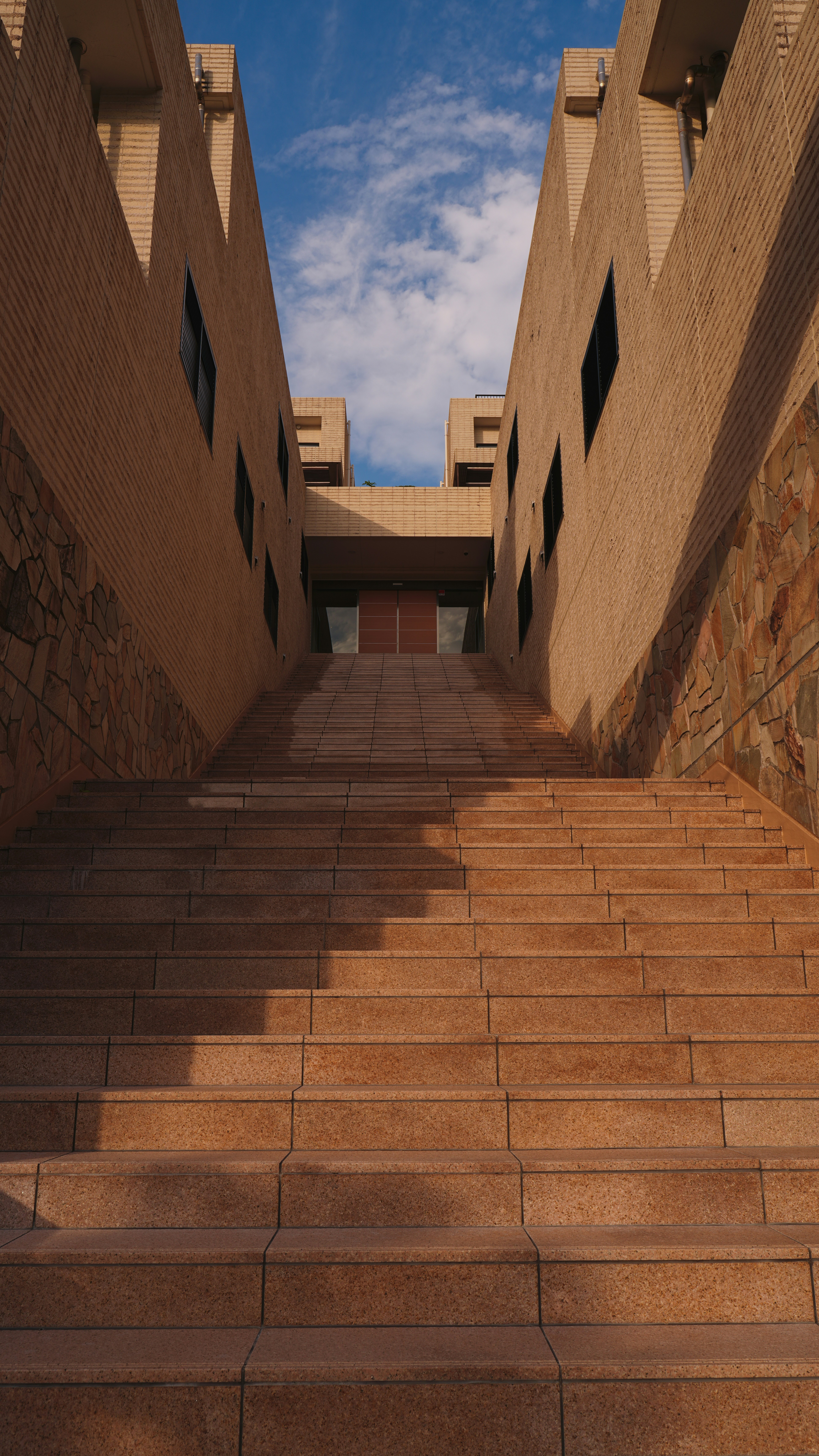 Axis of Ascent: Brick Staircase Framing a Skyward Door