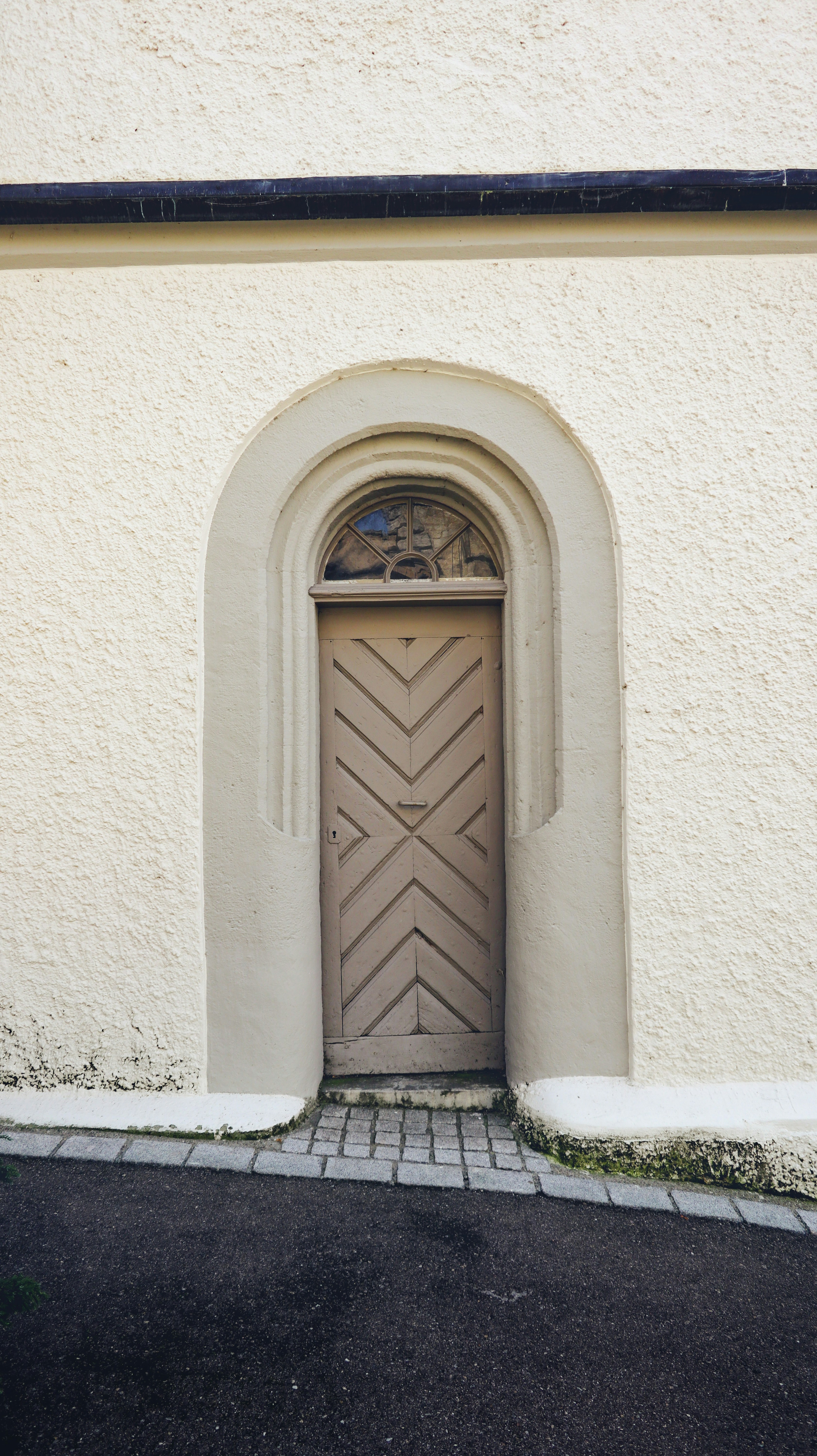Arched Portal with Chevron Doorway on Toned Stucco Wall