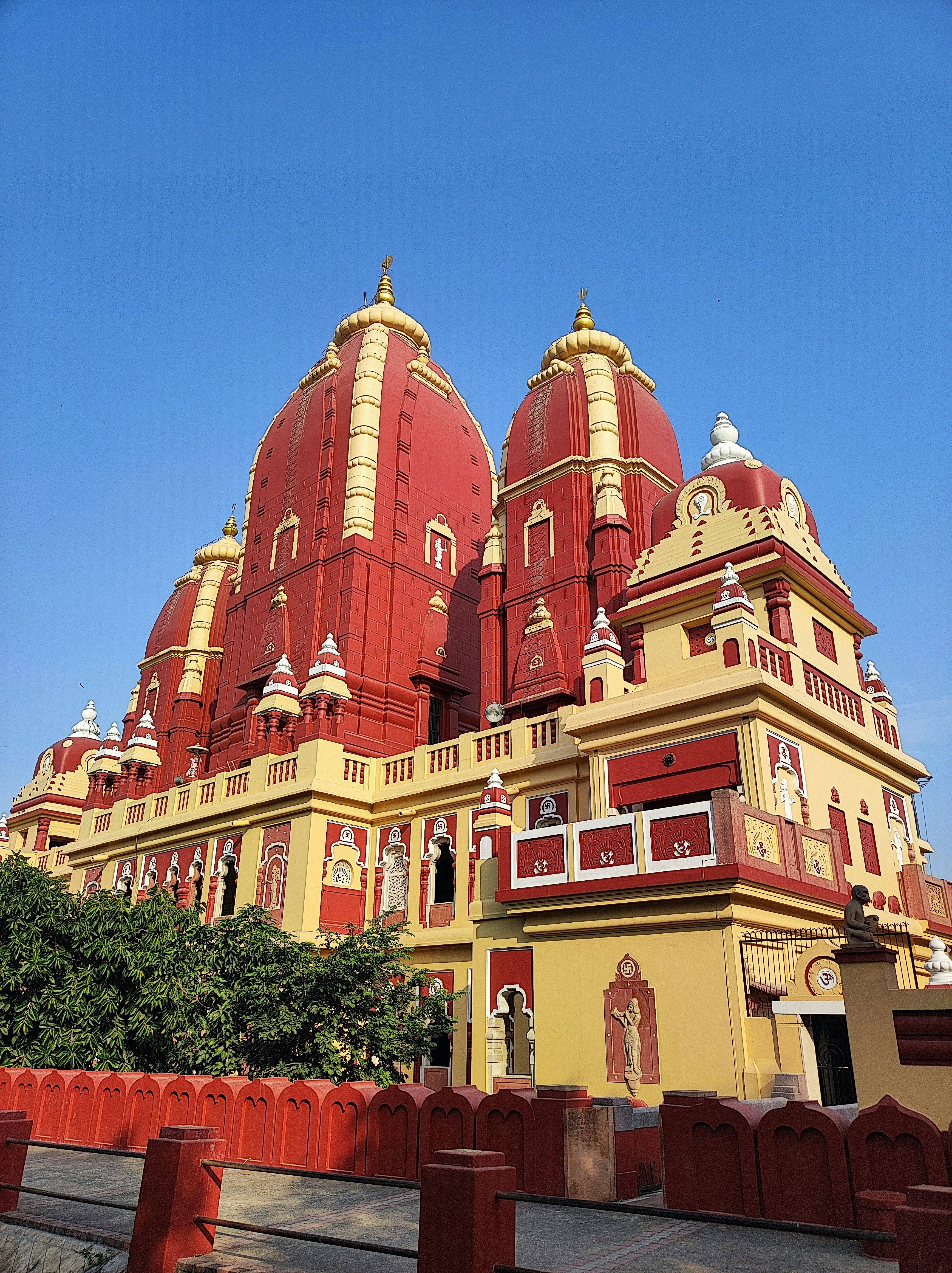 a large red and yellow building with a clock on it's side