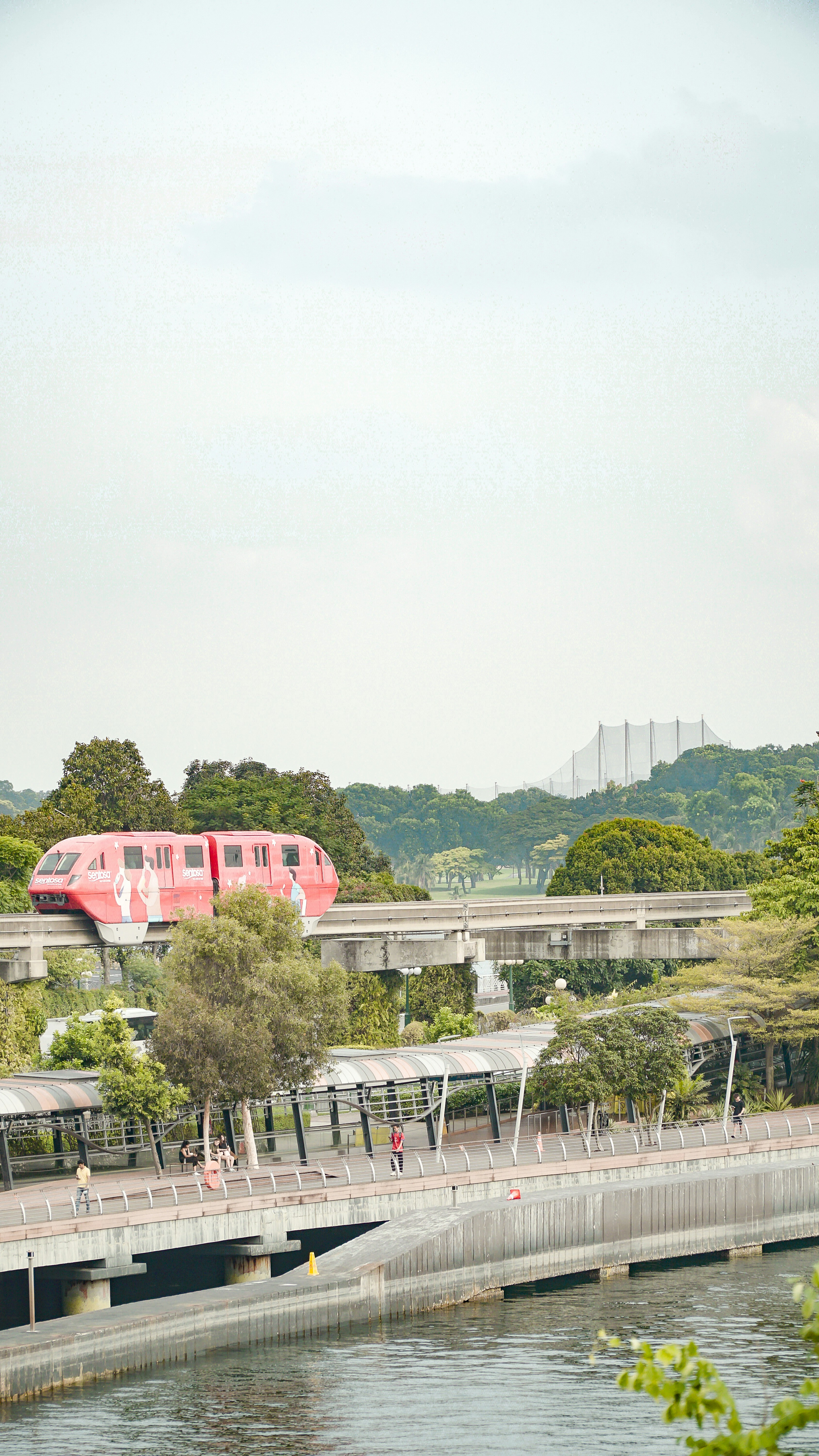 A red train traveling over a bridge next to a river photo – Free ...