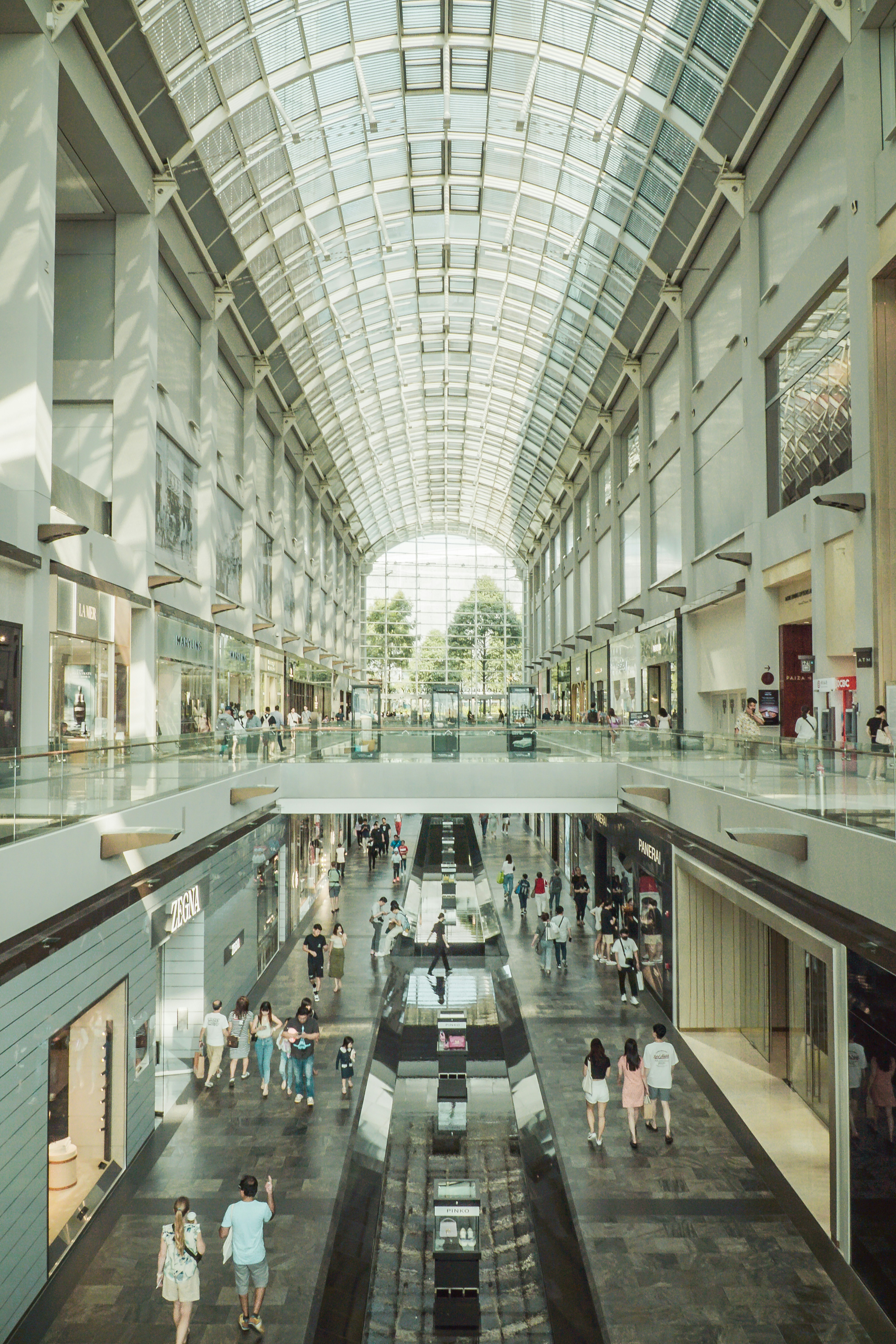 A group of people walking around inside of a building photo – Free ...