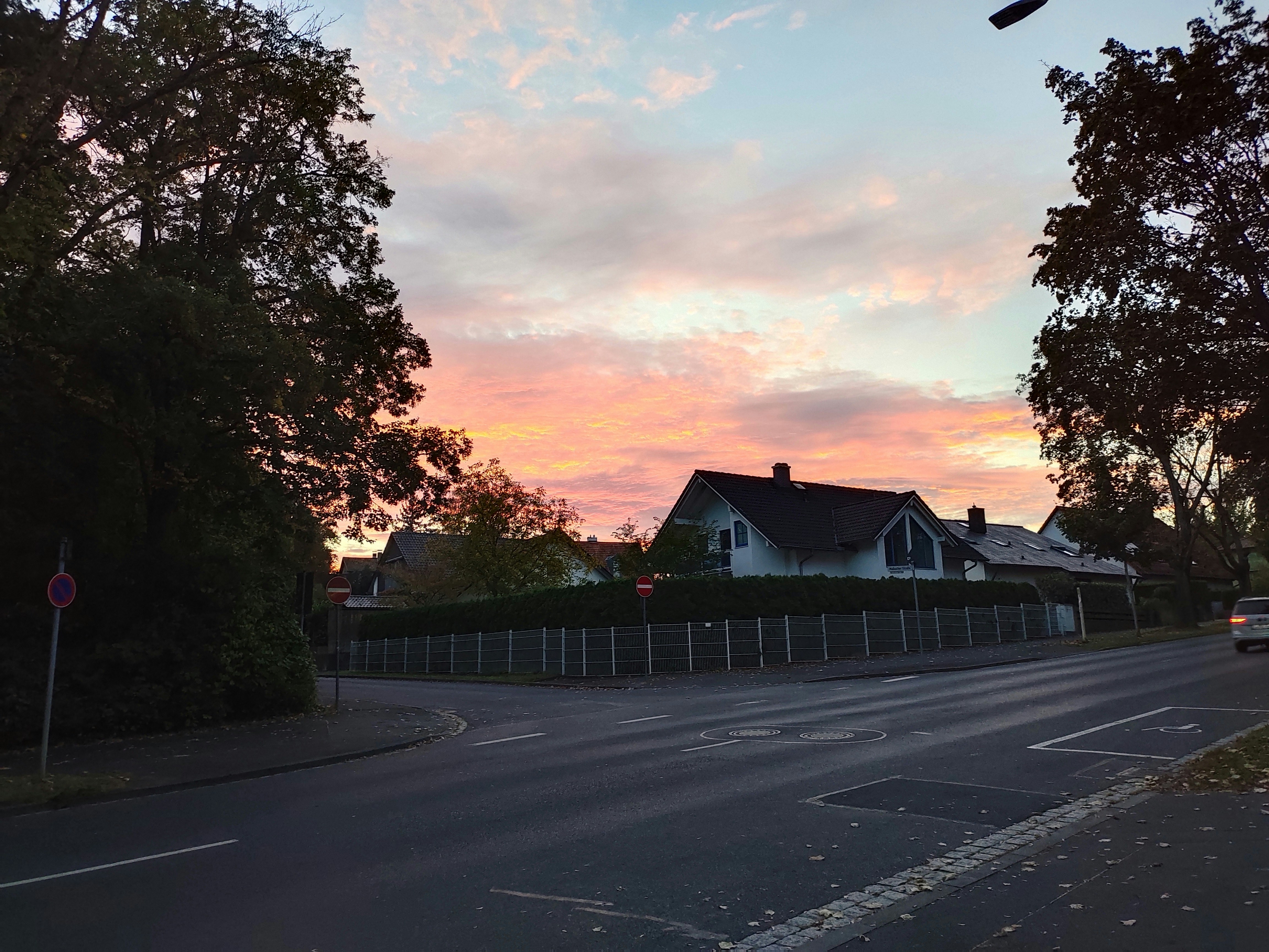 Crimson Skyline Over a Quiet Suburban Street at Dusk