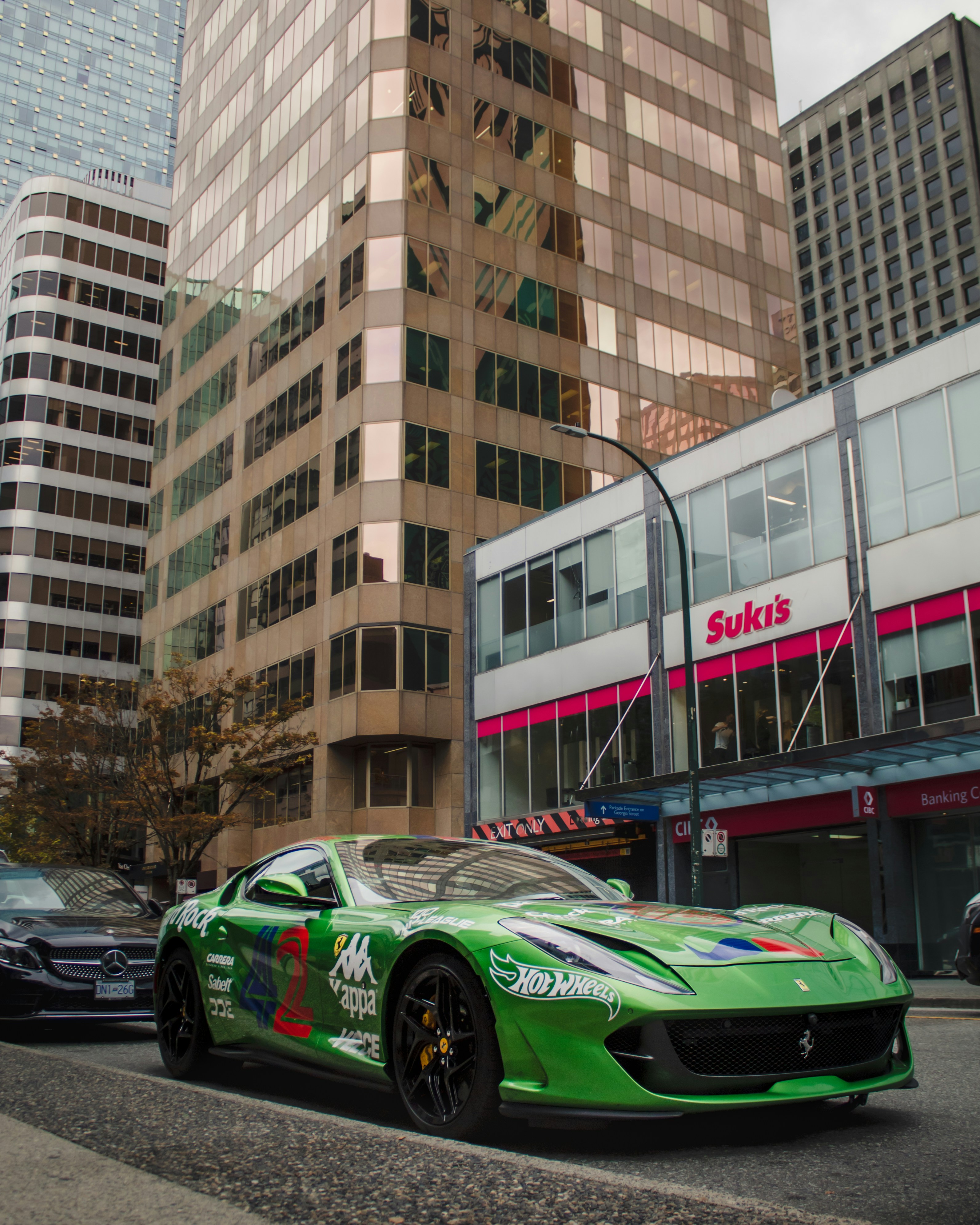 Emerald Ferrari Pierces the City's Glass Canyon