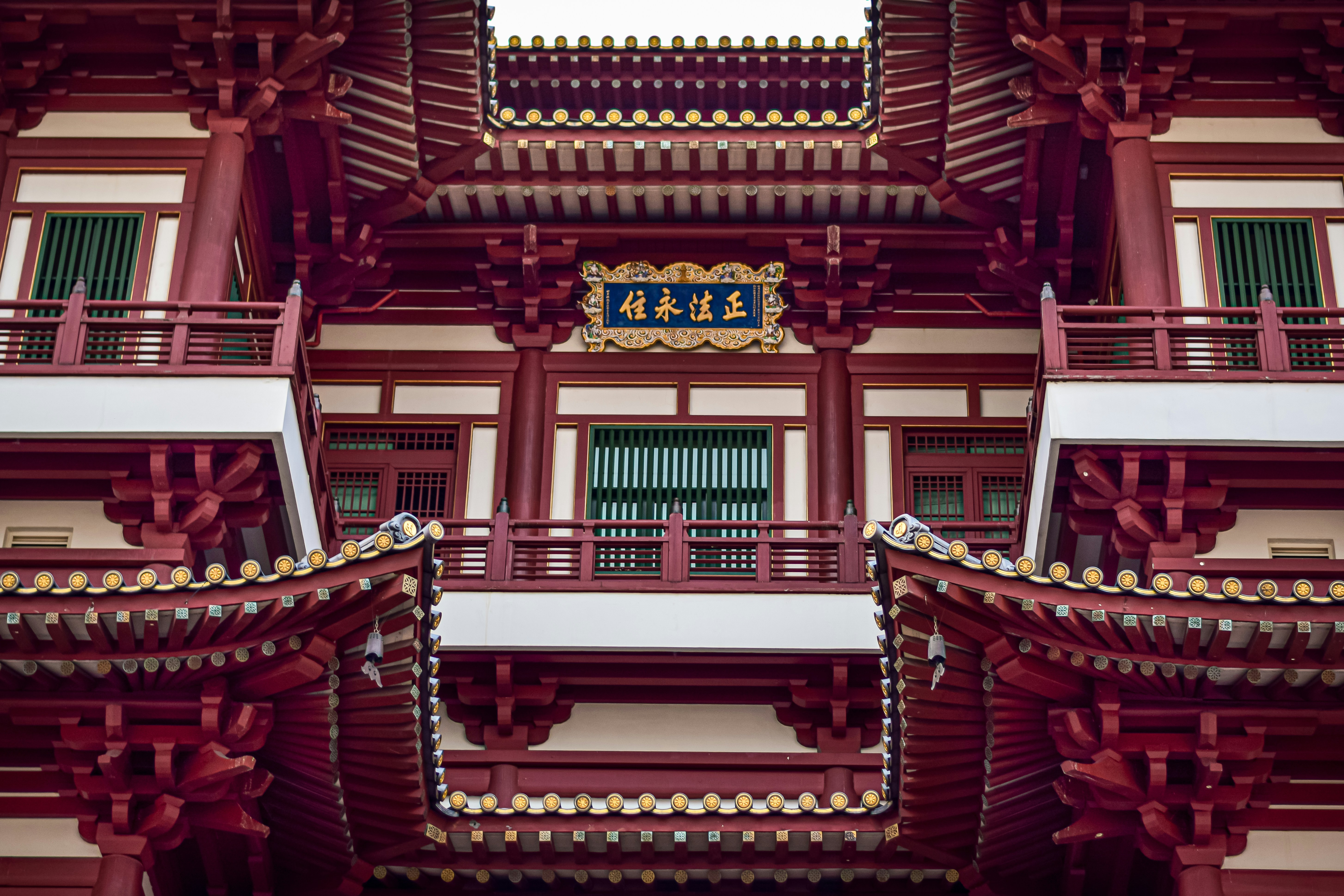 Intricate details of a traditional building featuring ornate wooden structures and vibrant red accents. The architecture reflects cultural heritage and craftsmanship.