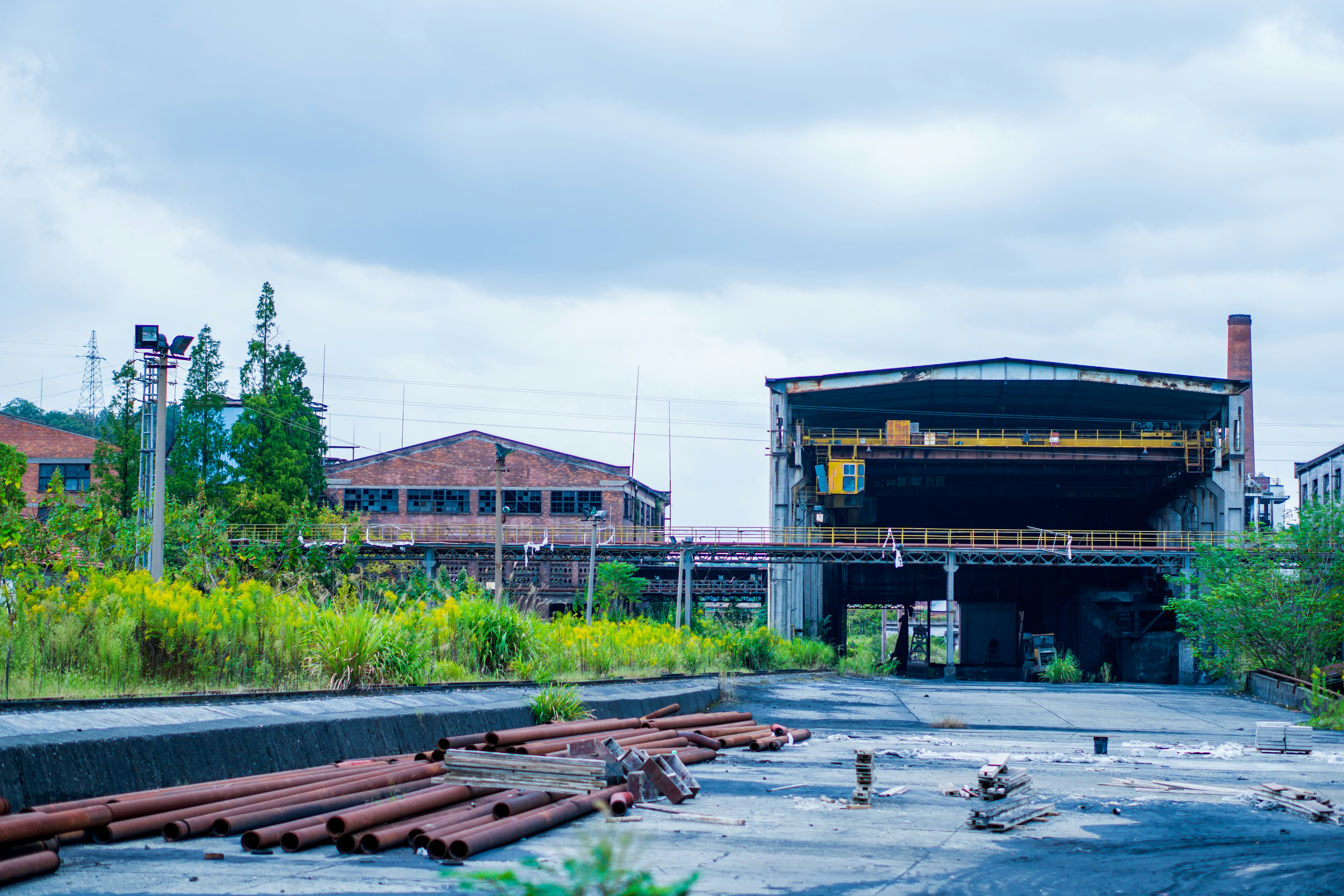 Quiet Relics: Weathered Warehouse Framed by Industrial Debris