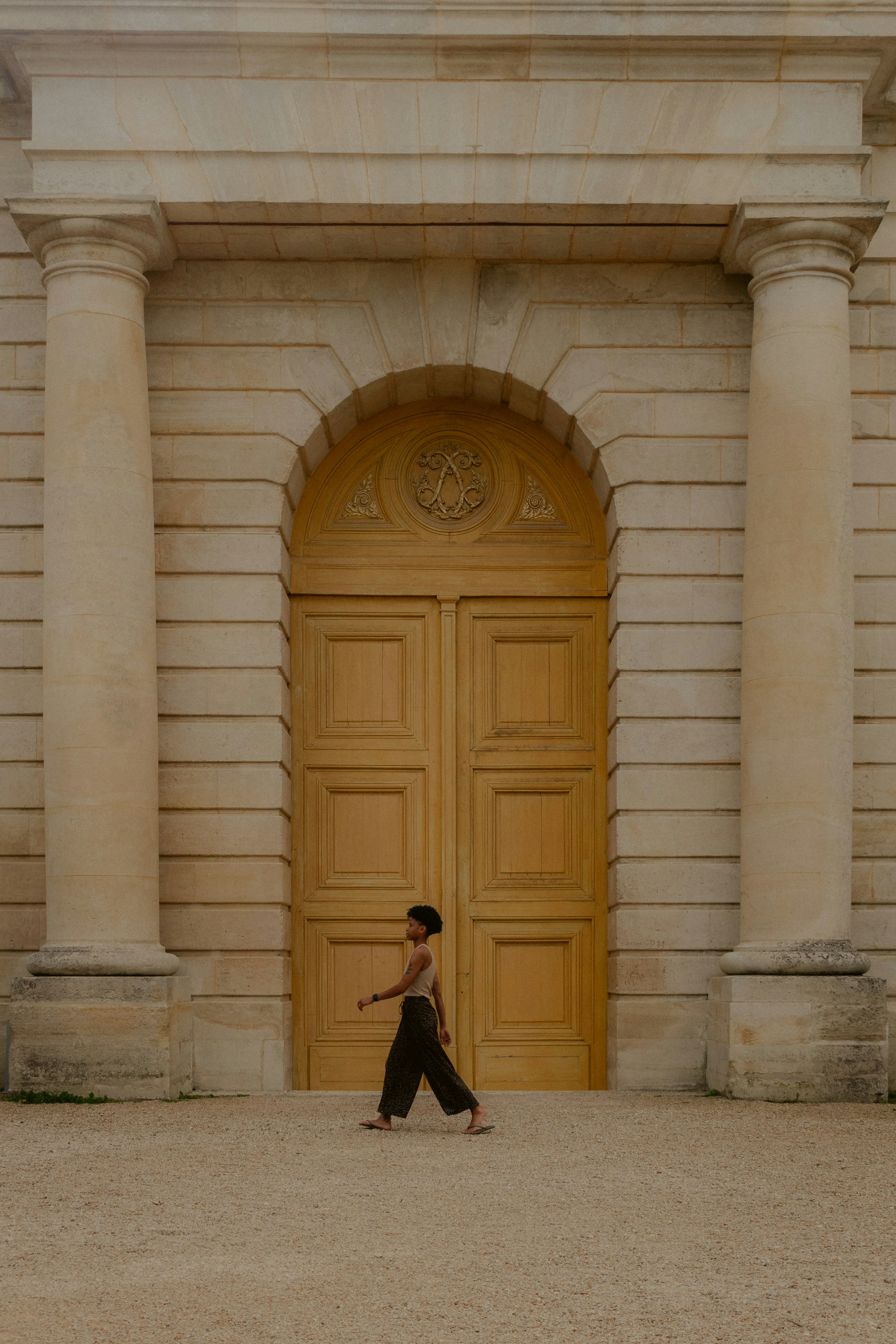 Threshold of Stone: A Lone Traveler Crossing a Monumental Doorway