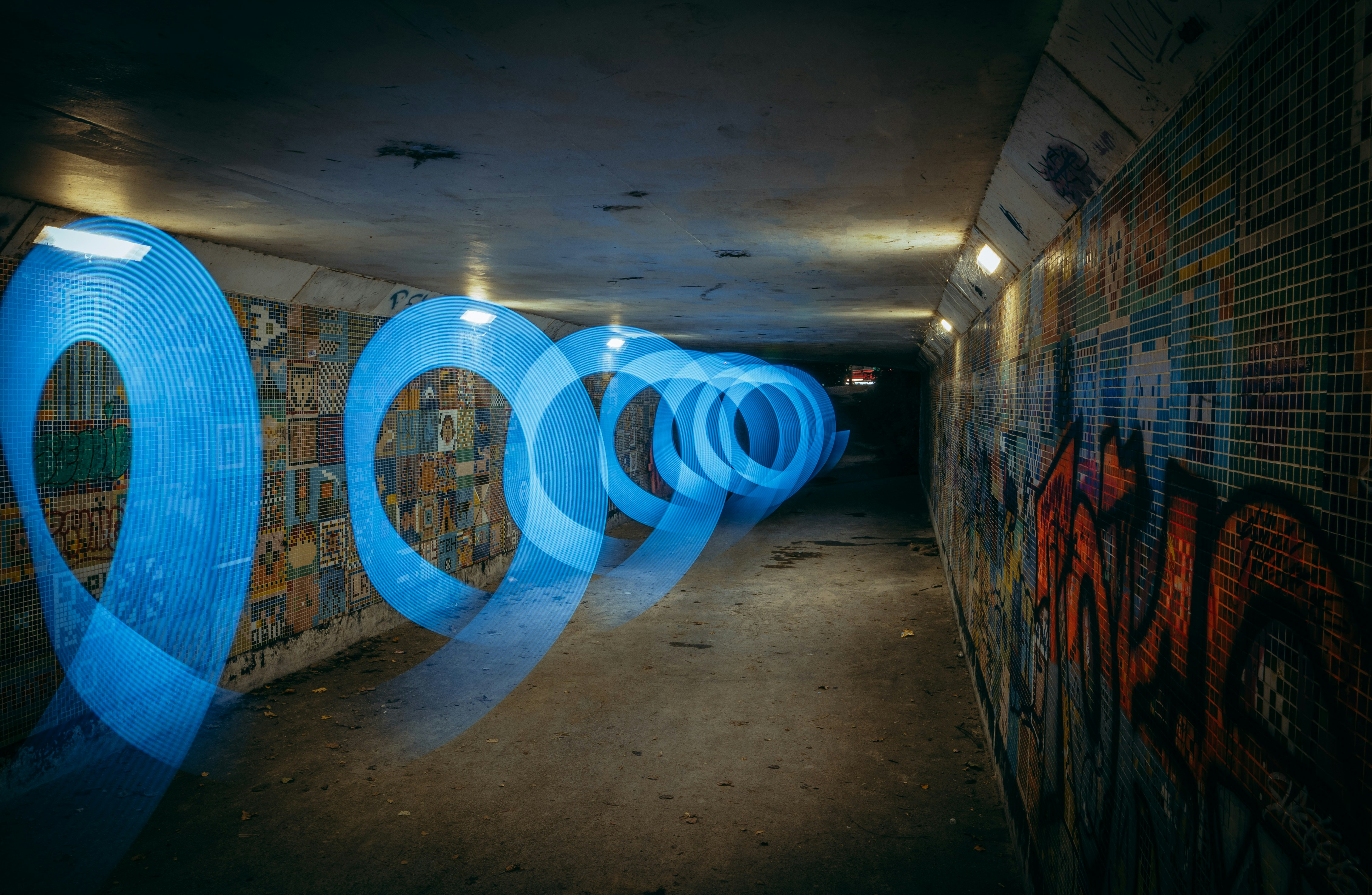 Blue Hoop Corridor: Long-exposure Light Rings Through a Graffiti Tunnel