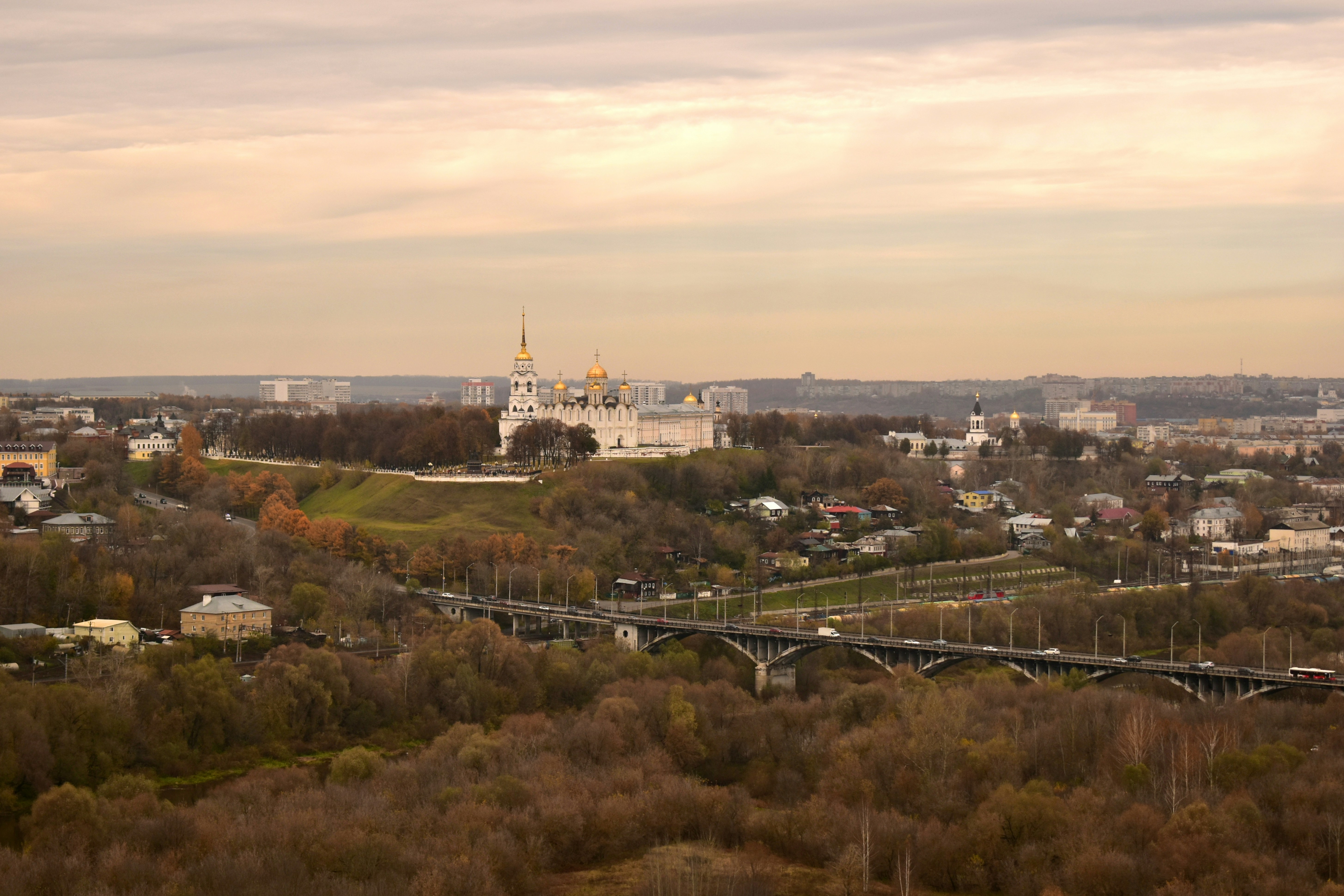 Hilltop Cathedral with Golden Domes Framed by a Riverside Bridge