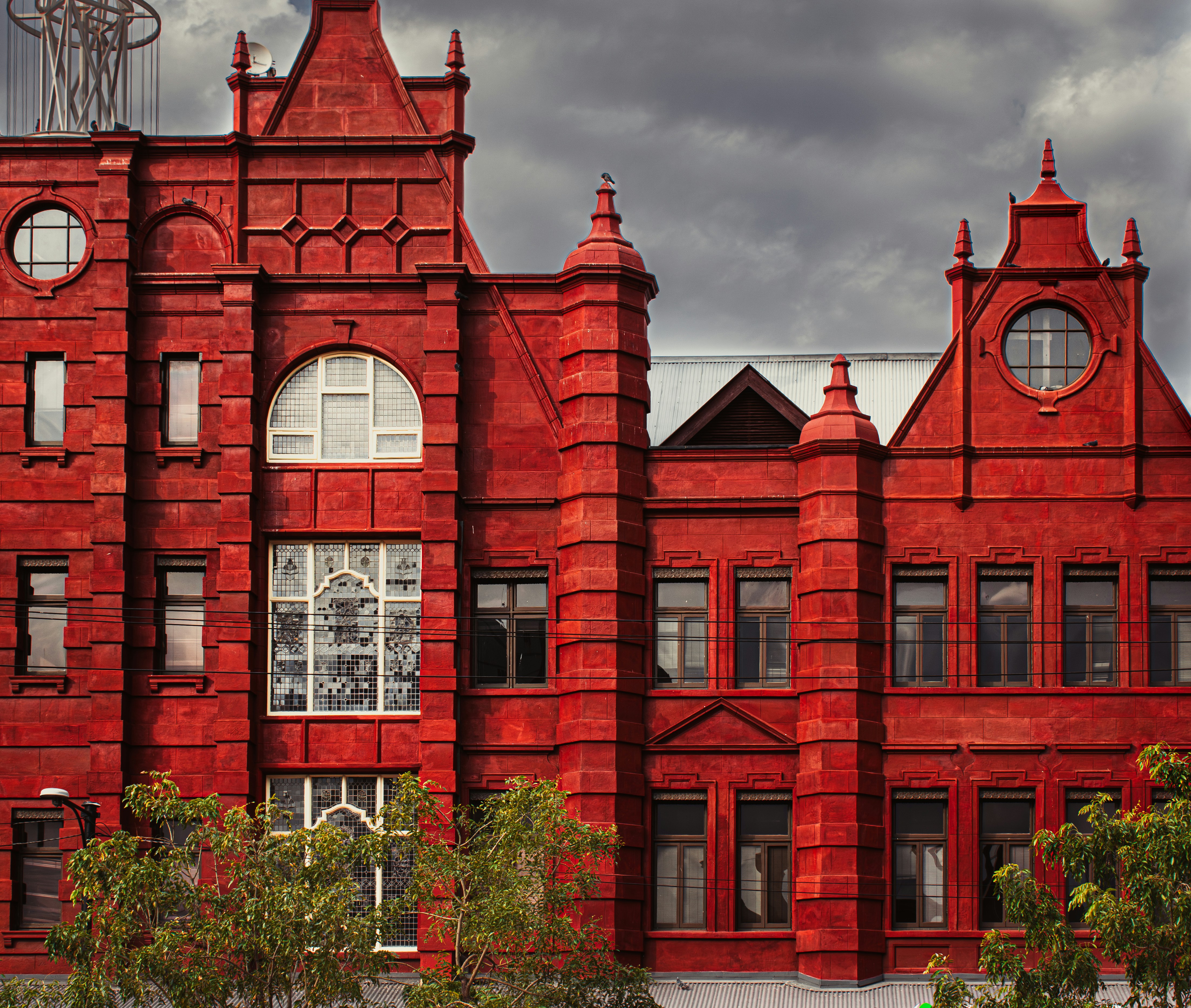 Crimson Gothic: A Red-Brick Facade Rising into a Stormy Skyline