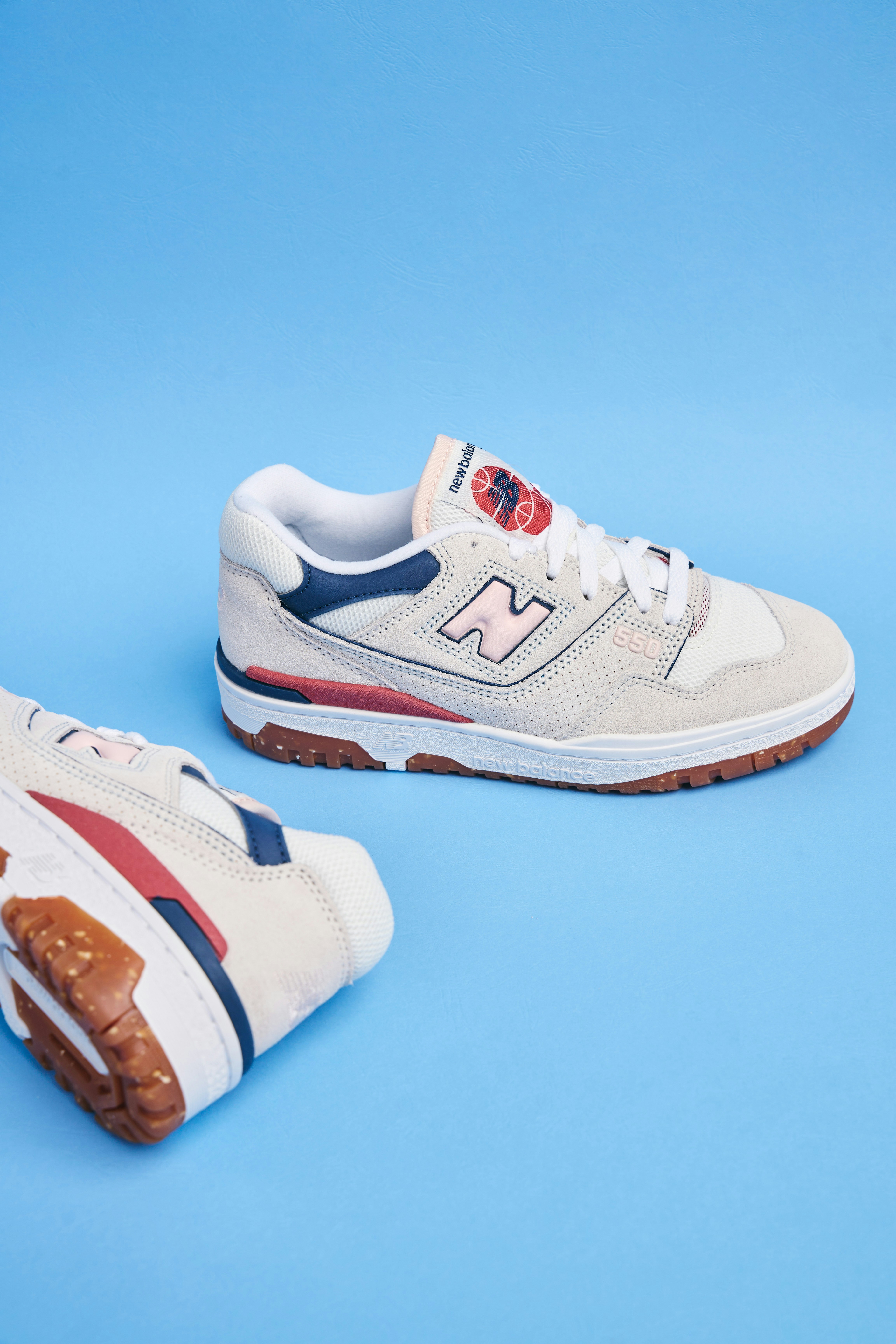A pair of new balance shoes on a blue background photo – Free Sneaker ...