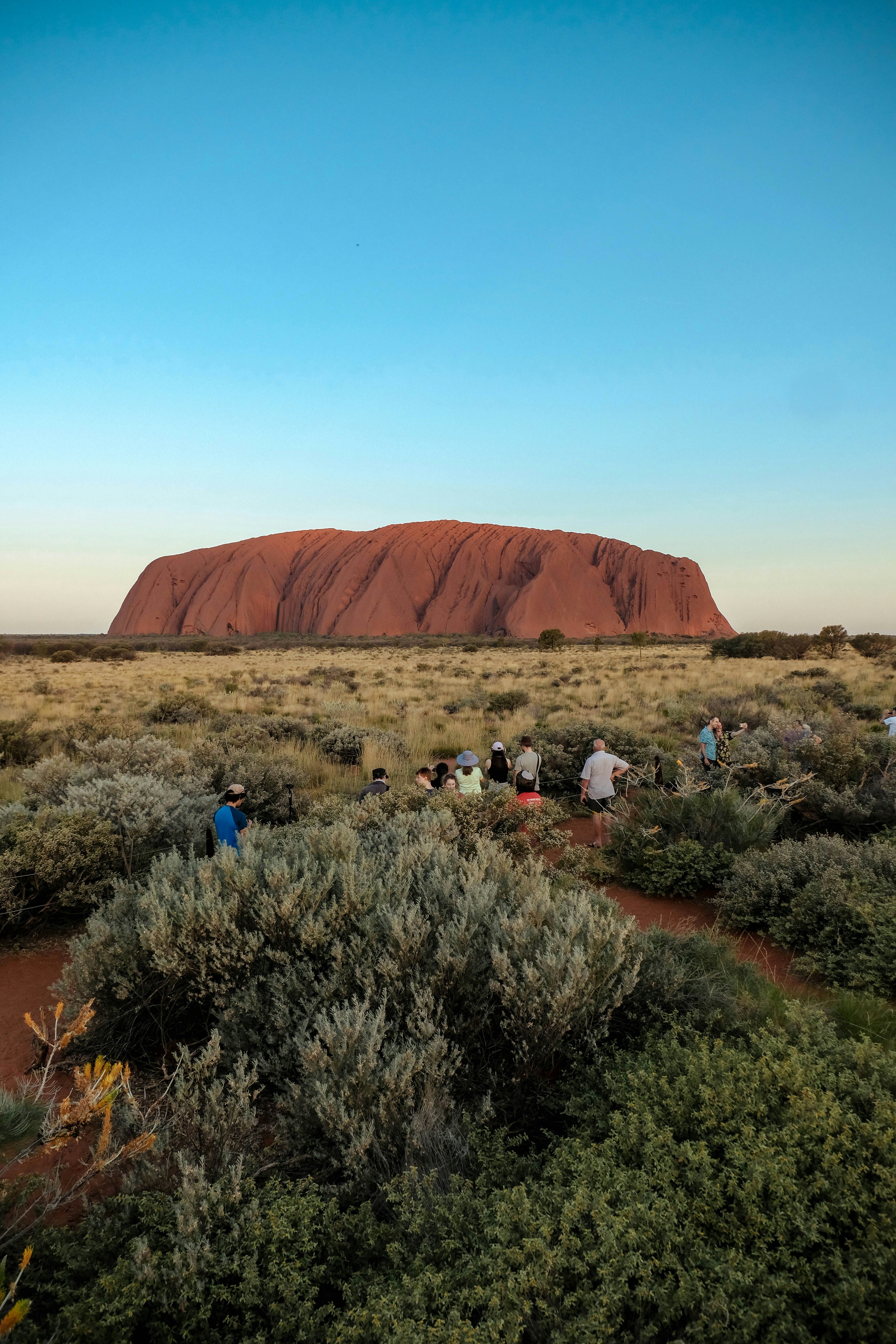 A group of people standing in front of a large rock photo – Free ...