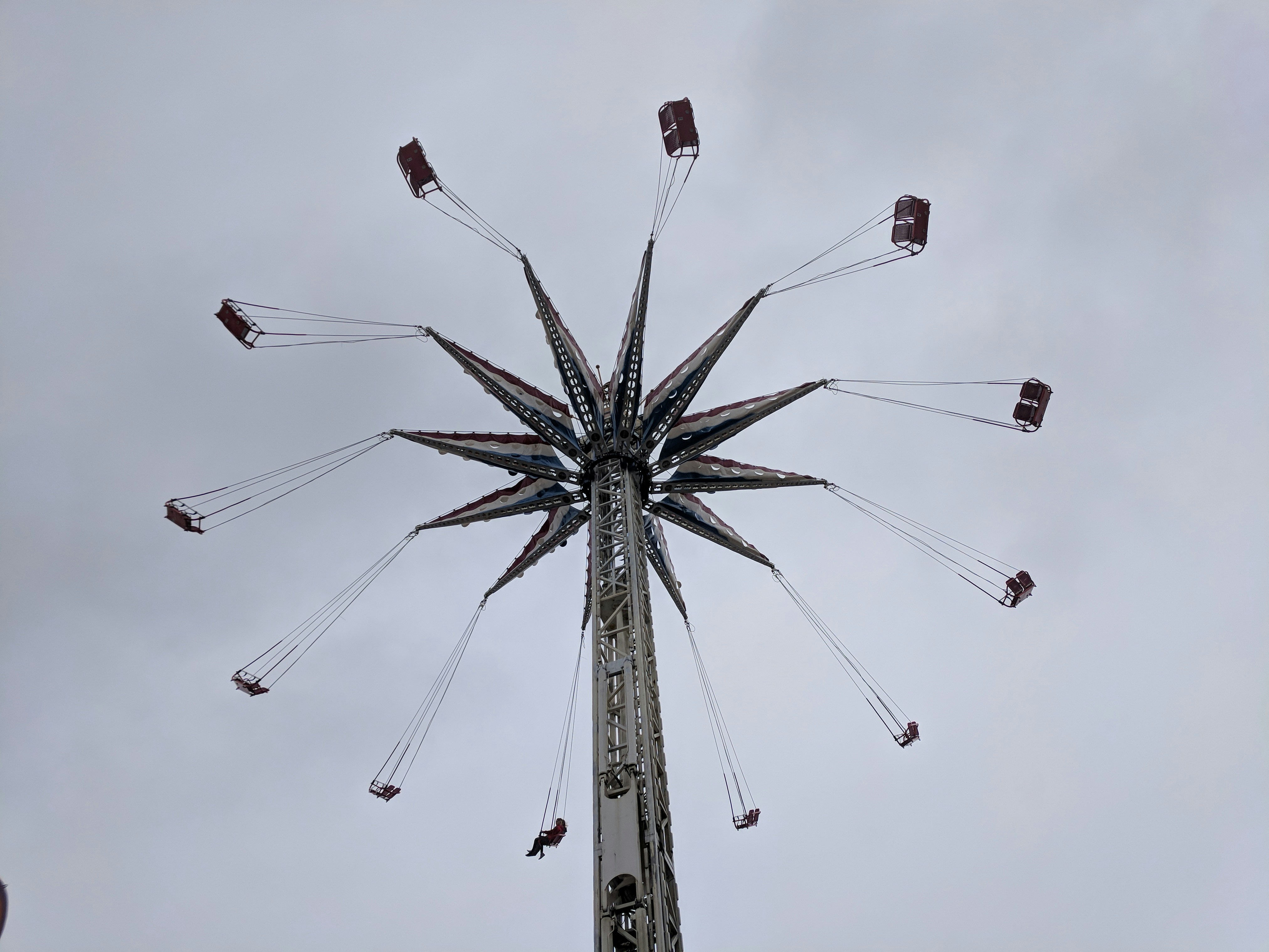A ferris wheel with flags flying in the sky photo – Free Amusement park ...