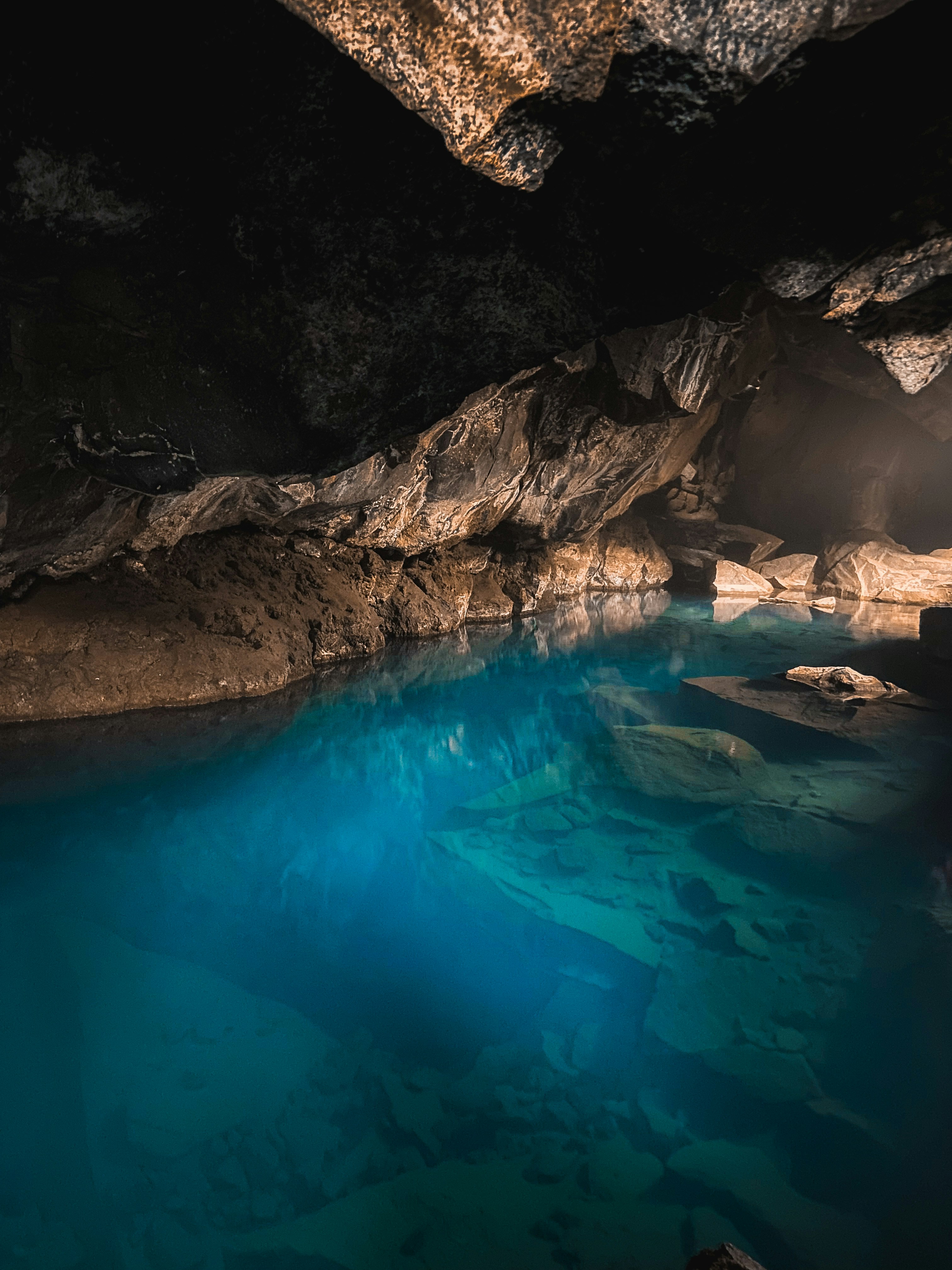 A large pool of water in a cave photo – Free Cave Image on Unsplash