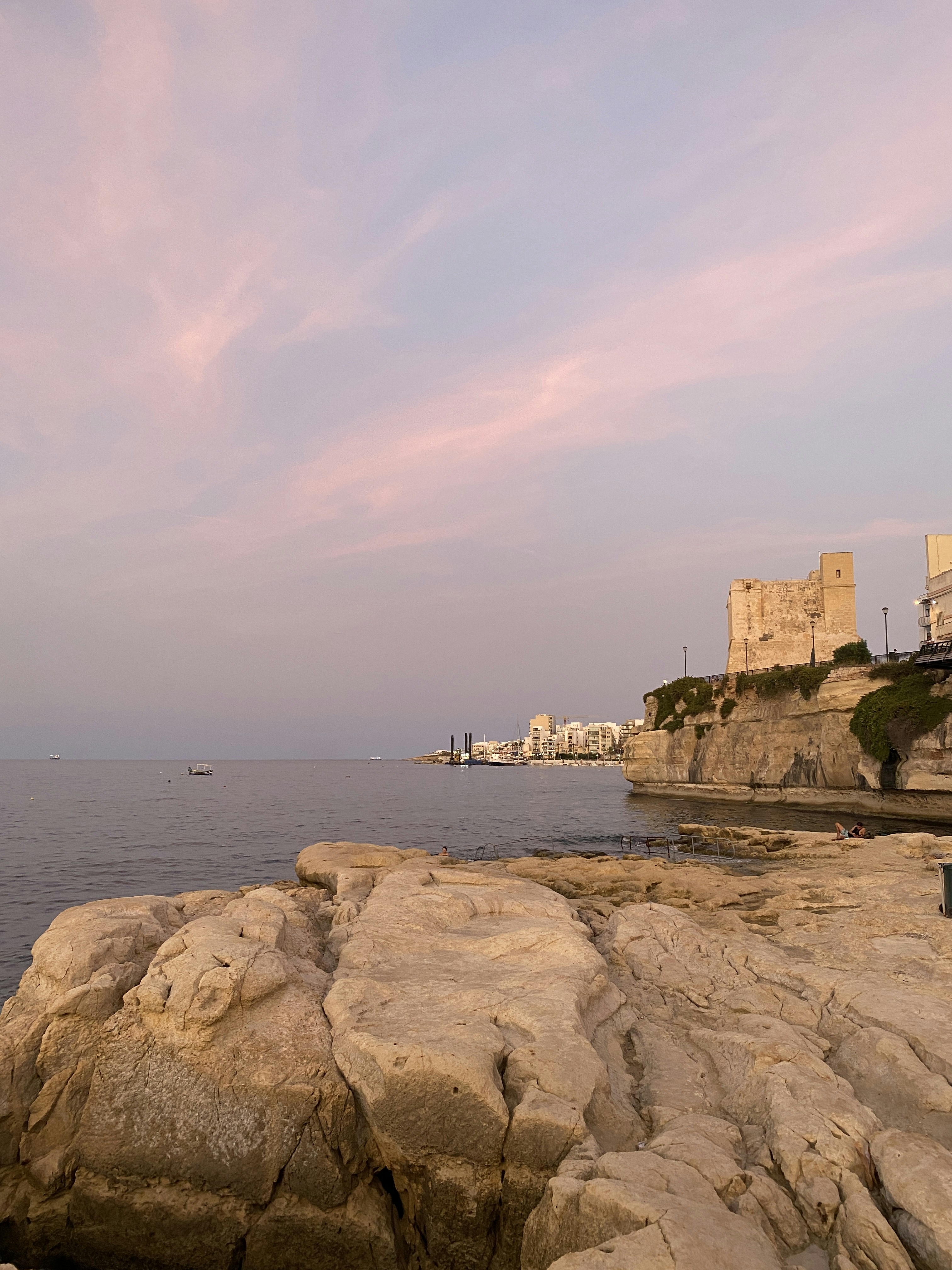 Fortress on the Cliff at Dusk Over a Pink-Tinted Gulf
