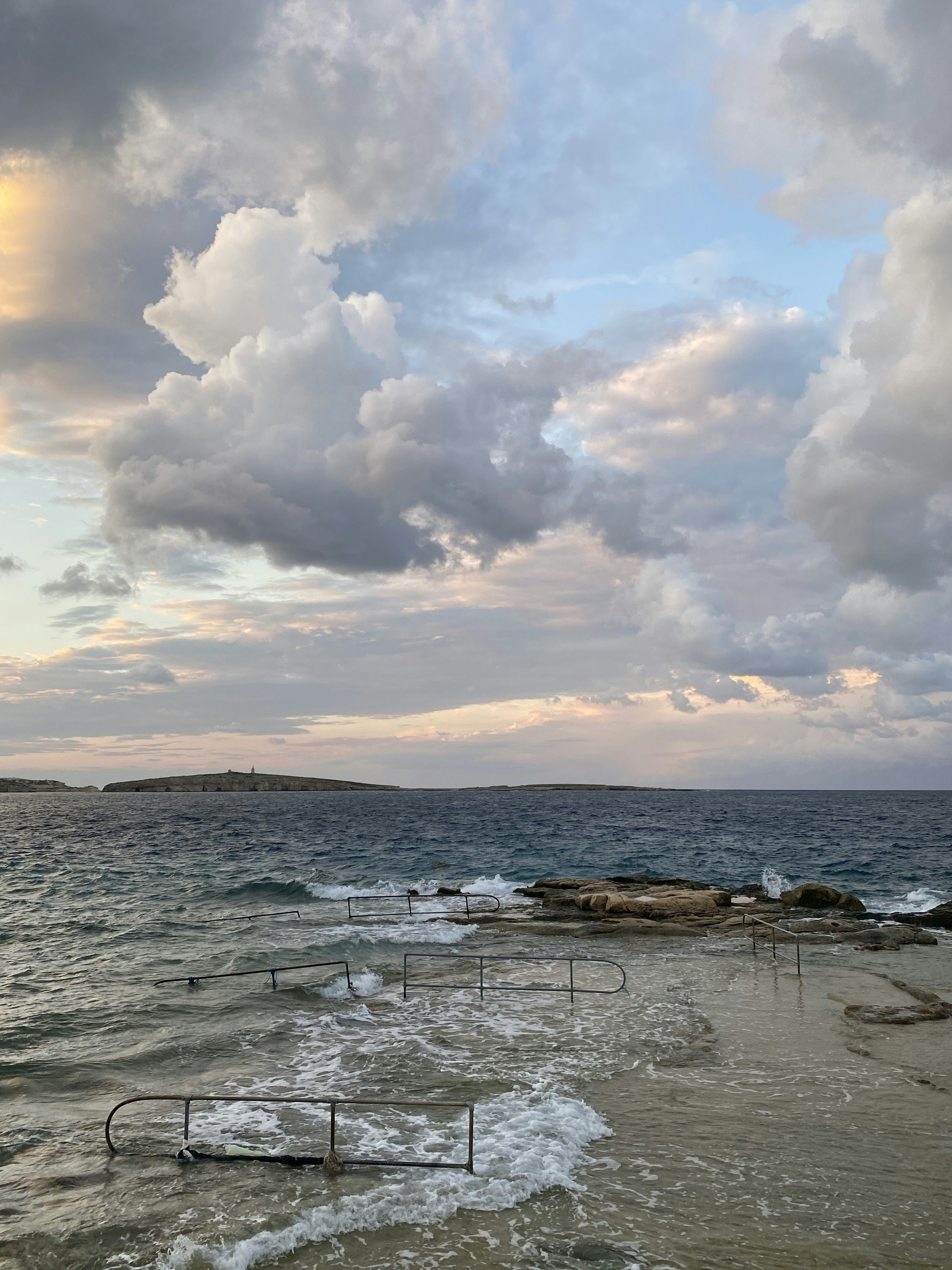 Dusk Over a Salt-Washed Shore: Clouds, Rails, and Quiet Waves