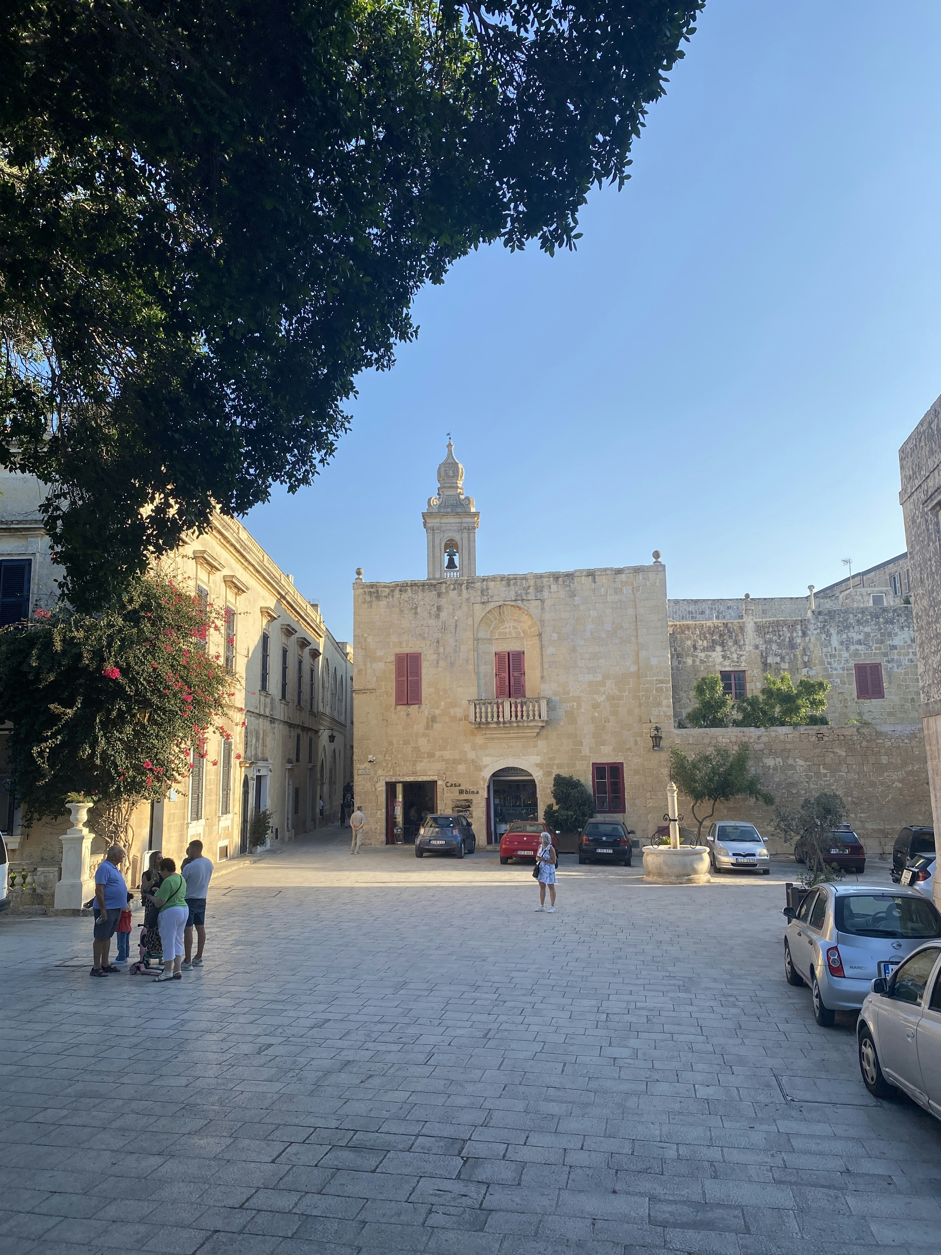 Sunlit Bell-Towered Facade: Central Anchor of a Stone Town Square