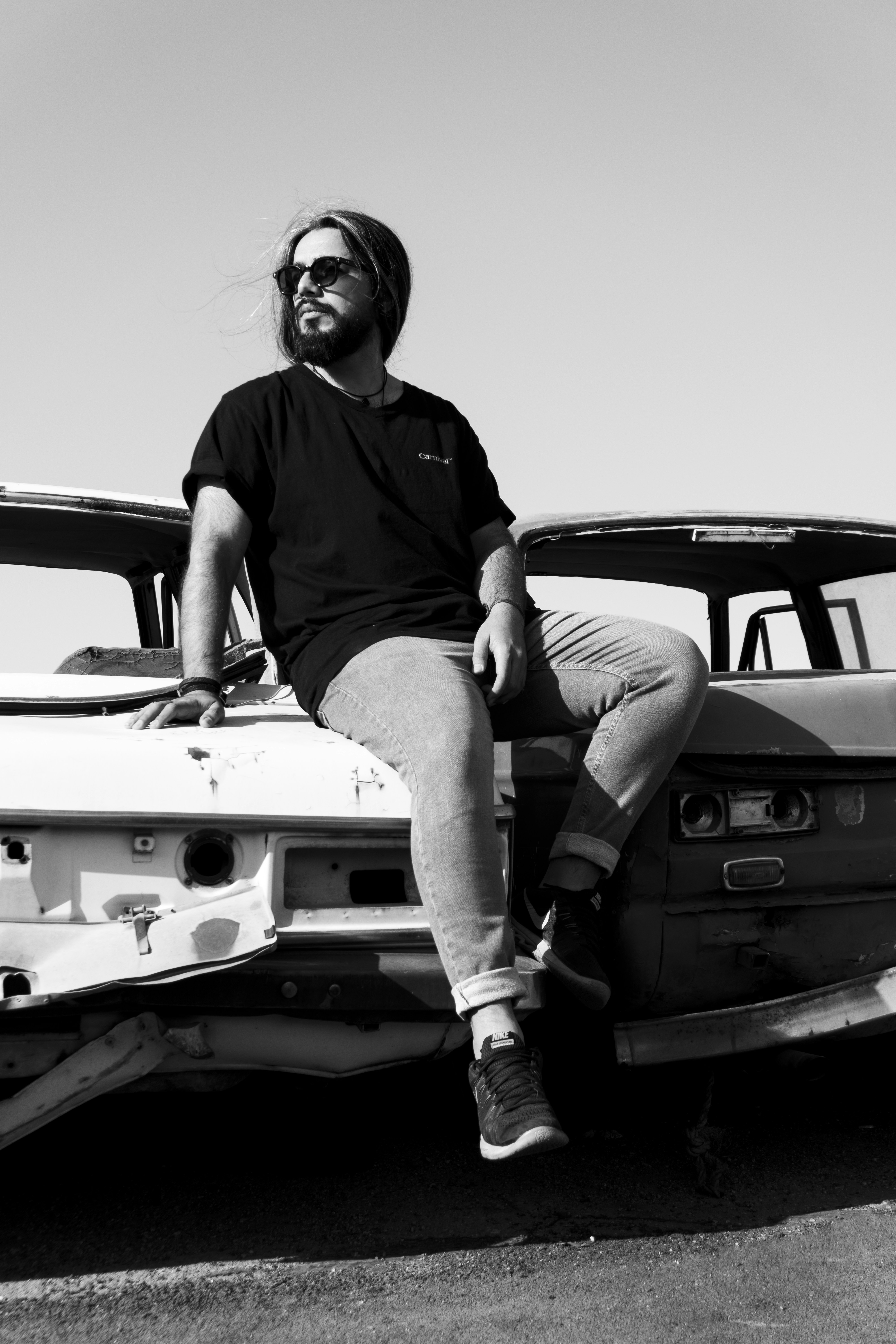 Portrait on Chrome and Dust: A Rider’s Repose on a Vintage Car